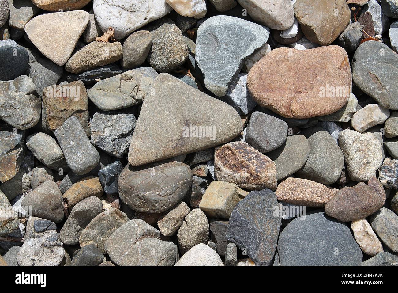Detailed close up view on pebbles and stones on a gravel ground texture ...