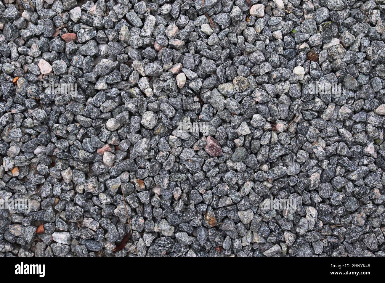 Detailed close up view on pebbles and stones on a gravel ground texture ...