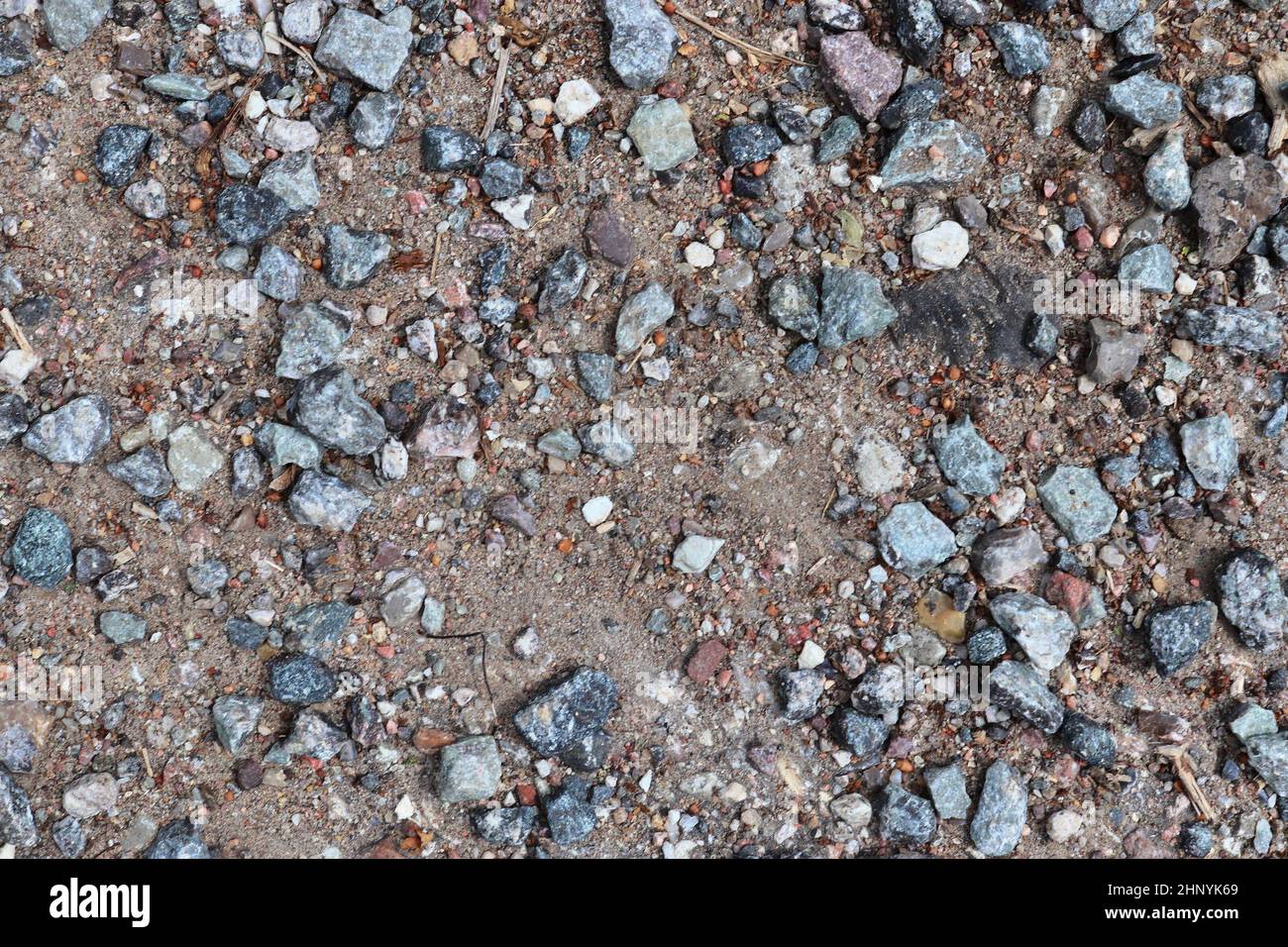 Detailed close up view on pebbles and stones on a gravel ground texture ...