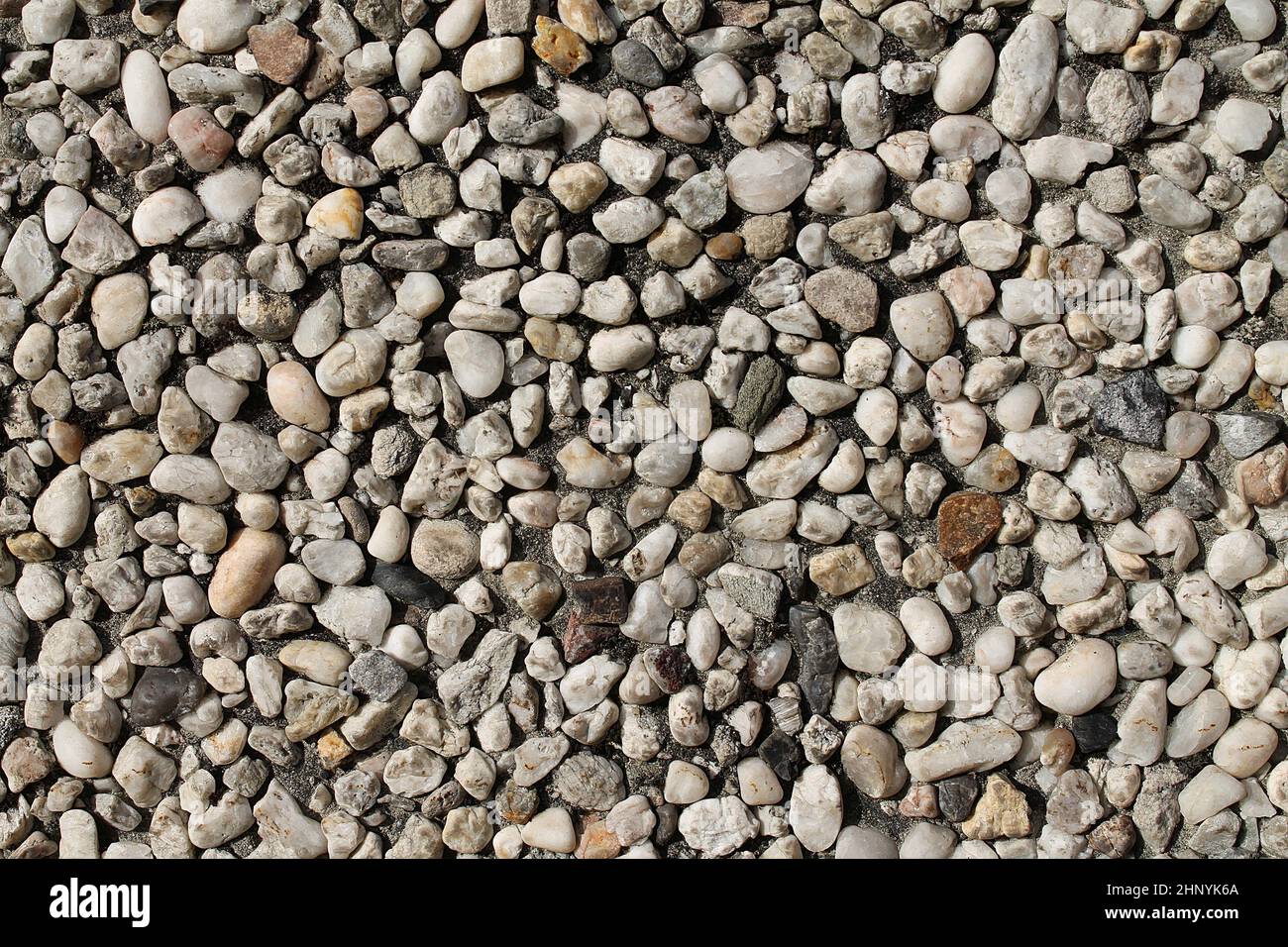 Detailed close up view on pebbles and stones on a gravel ground texture ...