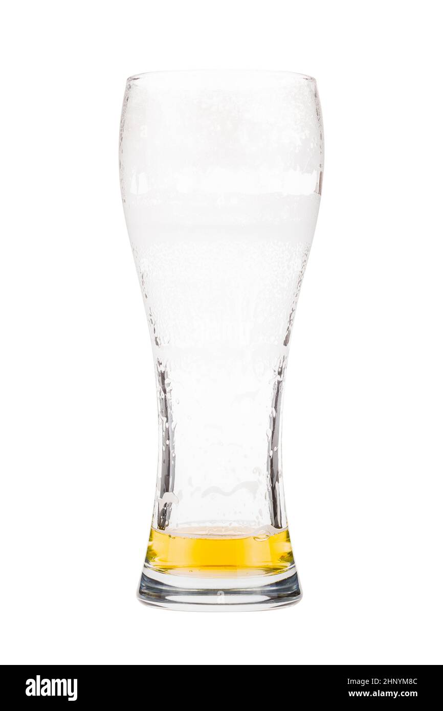 Tall beer glass almost full with lager beer, in the process of drinking ...