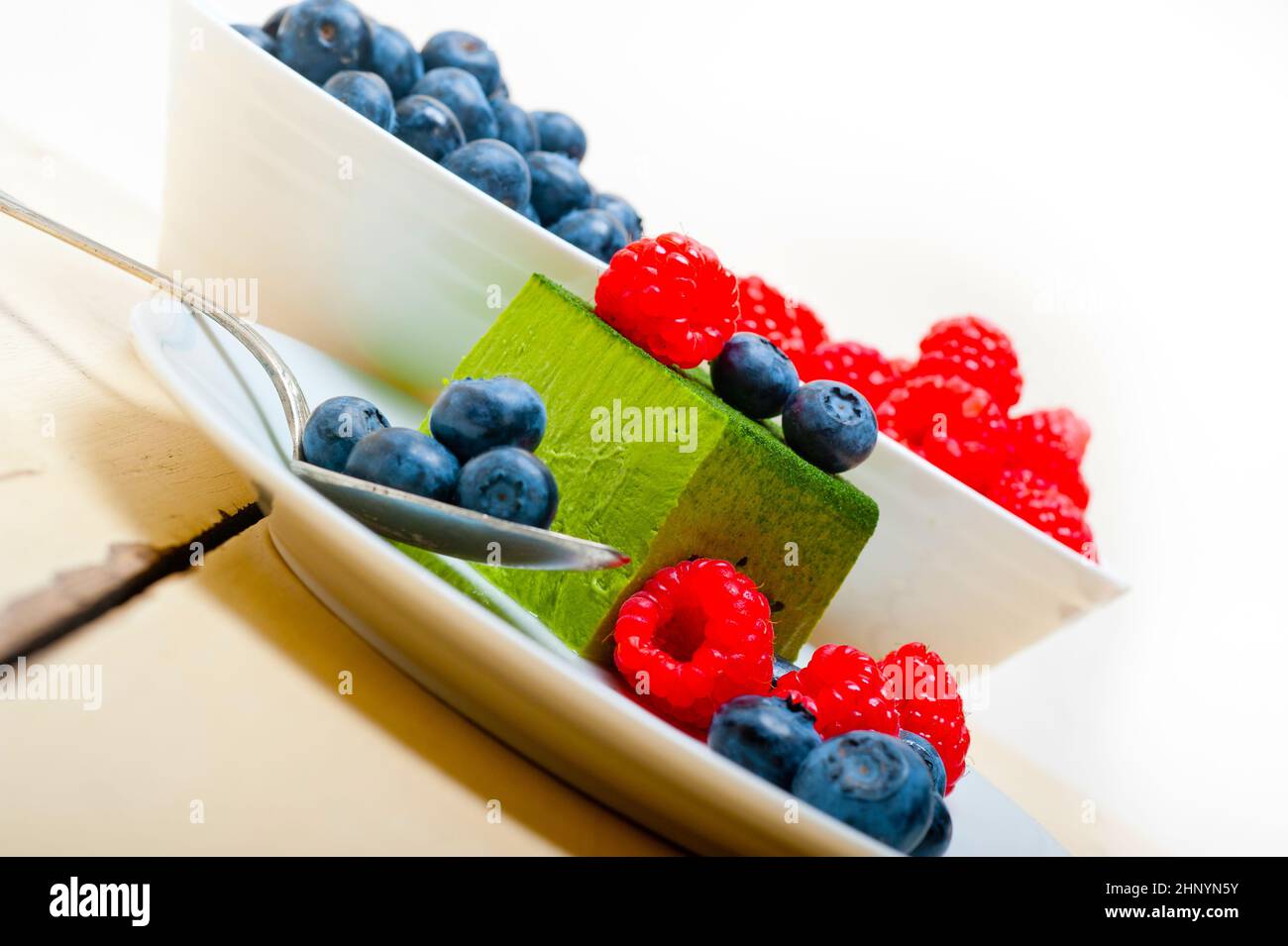 green tea matcha mousse cake with raspberries and blueberries on top ...