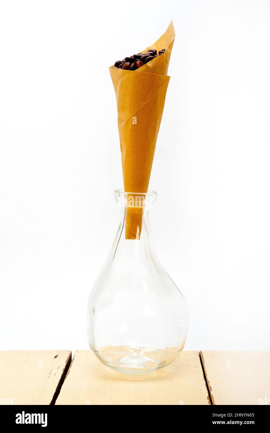 espresso coffee beans on a paper cone cornucopia over white background ...