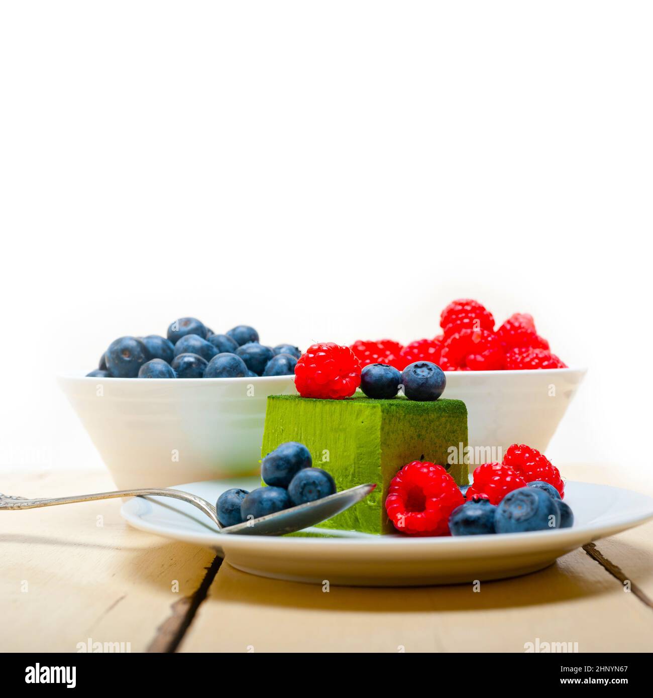 green tea matcha mousse cake with raspberries and blueberries on top ...