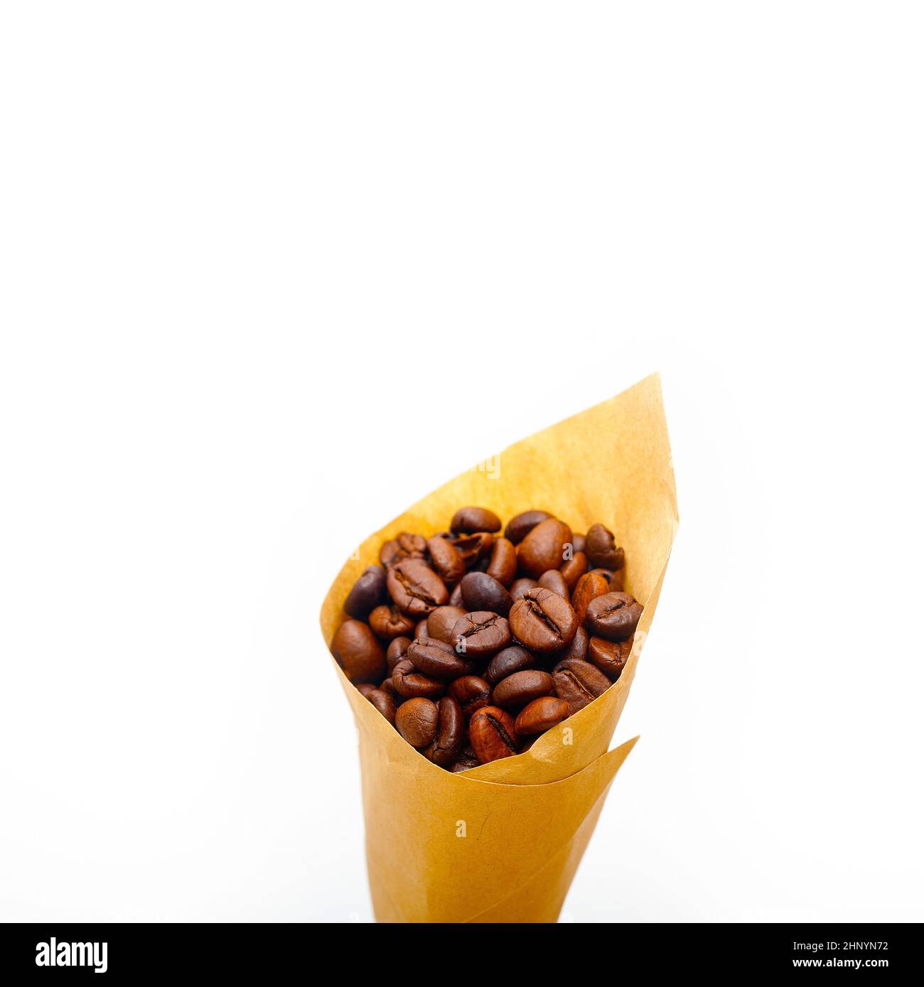 espresso coffee beans on a paper cone cornucopia over white background ...