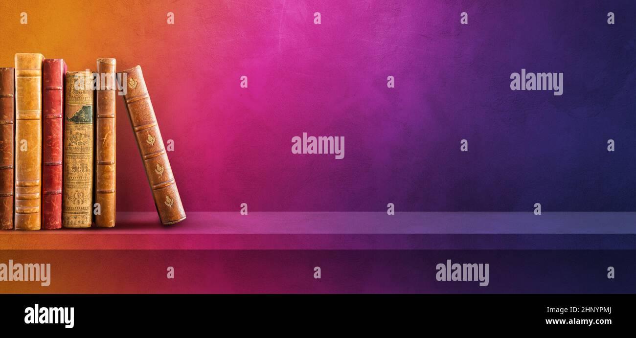 Row of old books on rainbow shelf. Horizontal background banner Stock Photo - Alamy