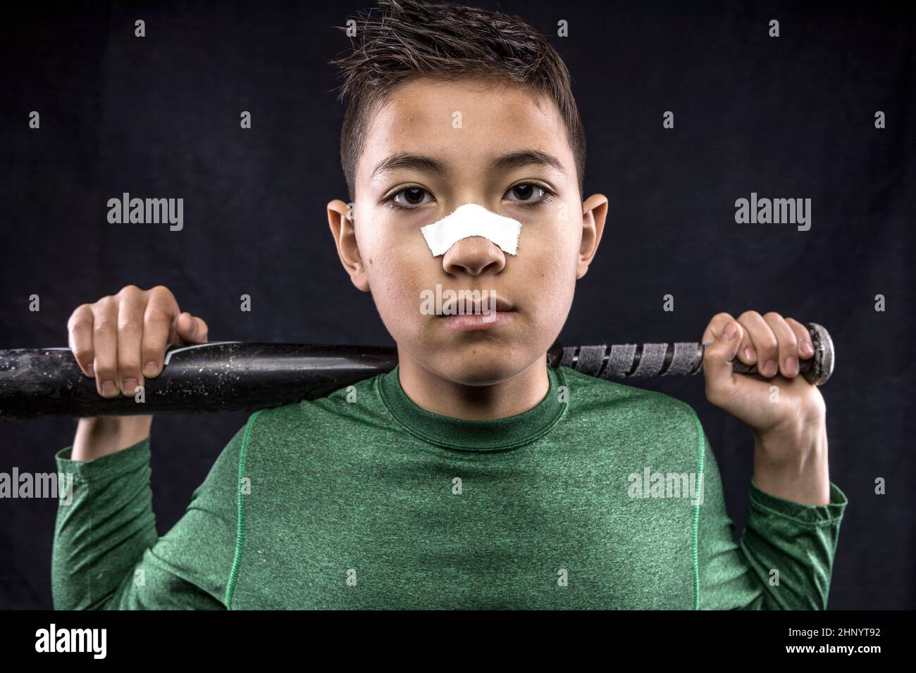 A studio portraiture of a boy holding a baseball bat Stock Photo - Alamy