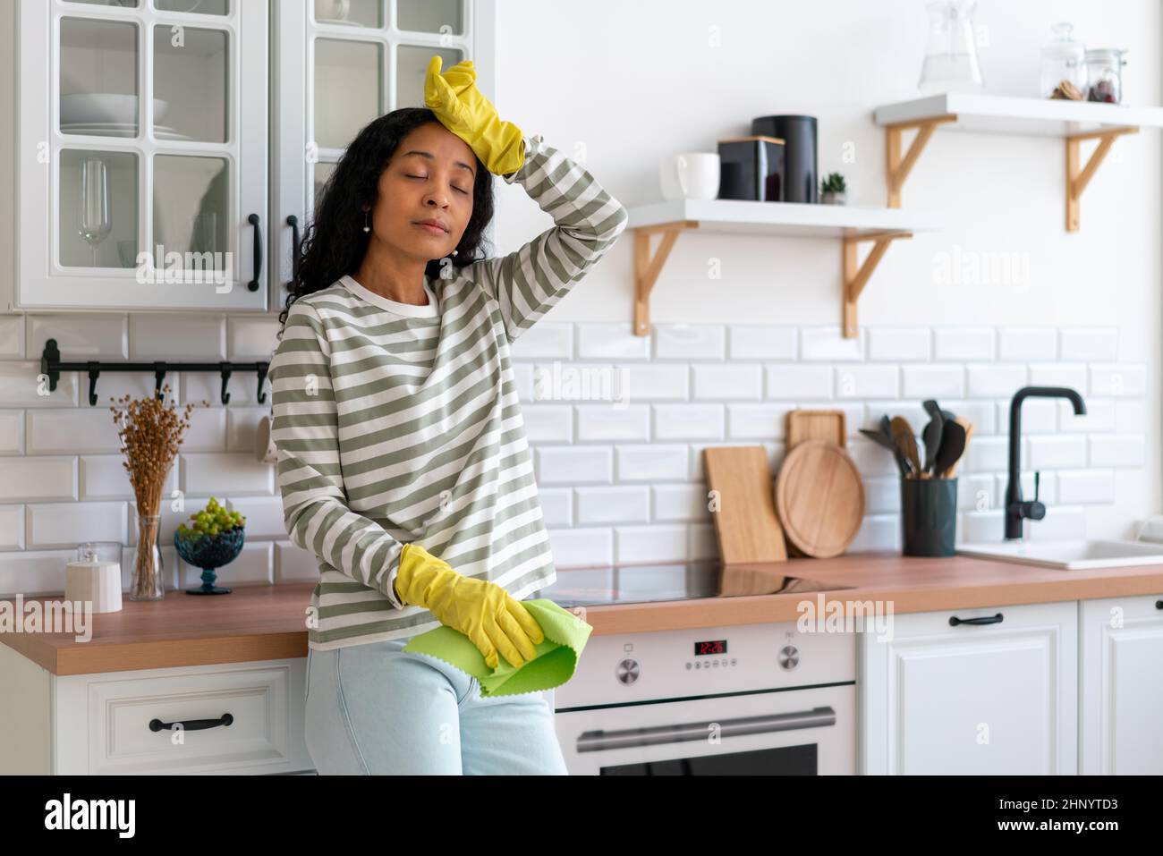 African-american female finished cleaning kitchen. Tired of dust ...