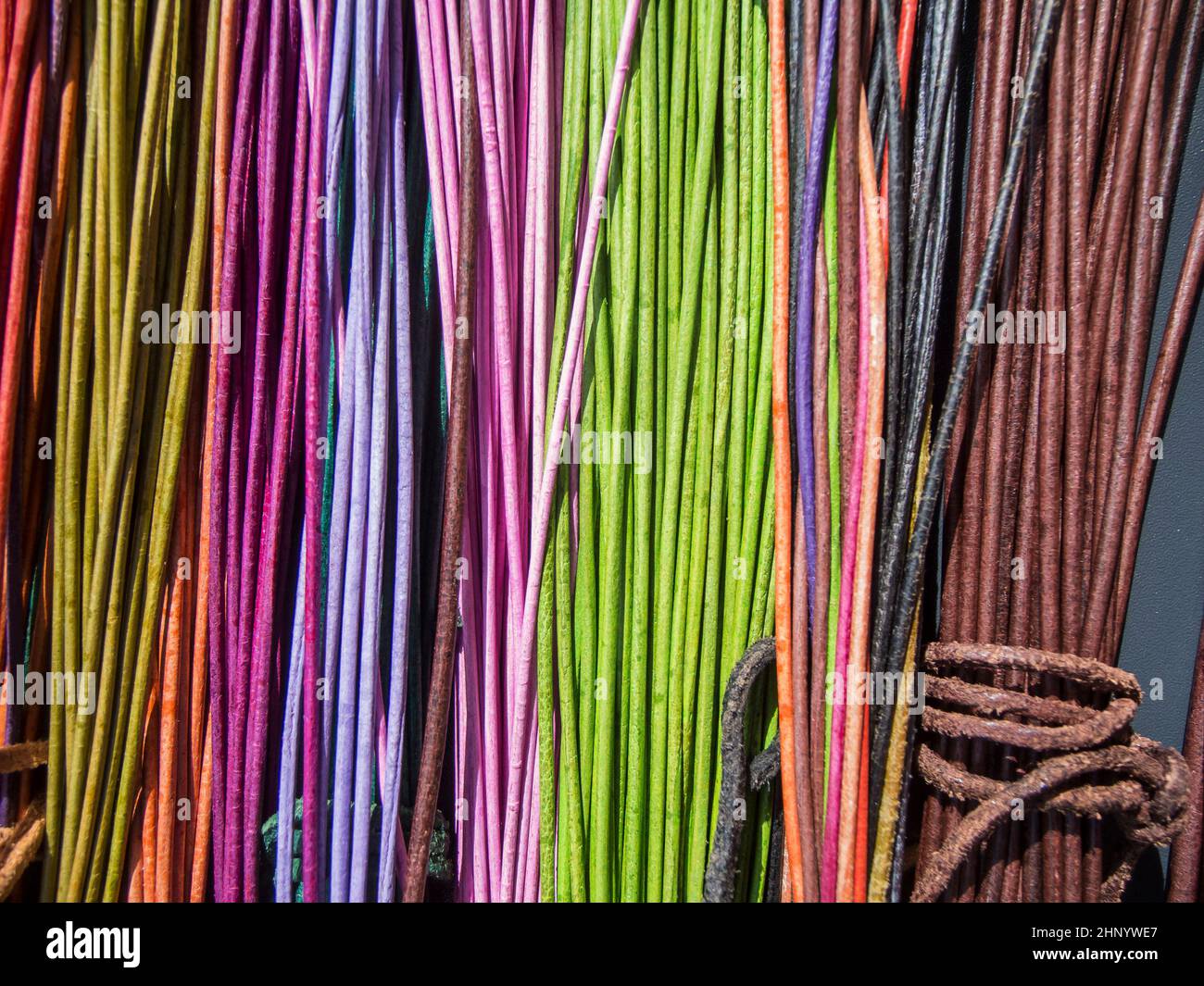 Red and orange colored leather cords with knots on a table in the ...