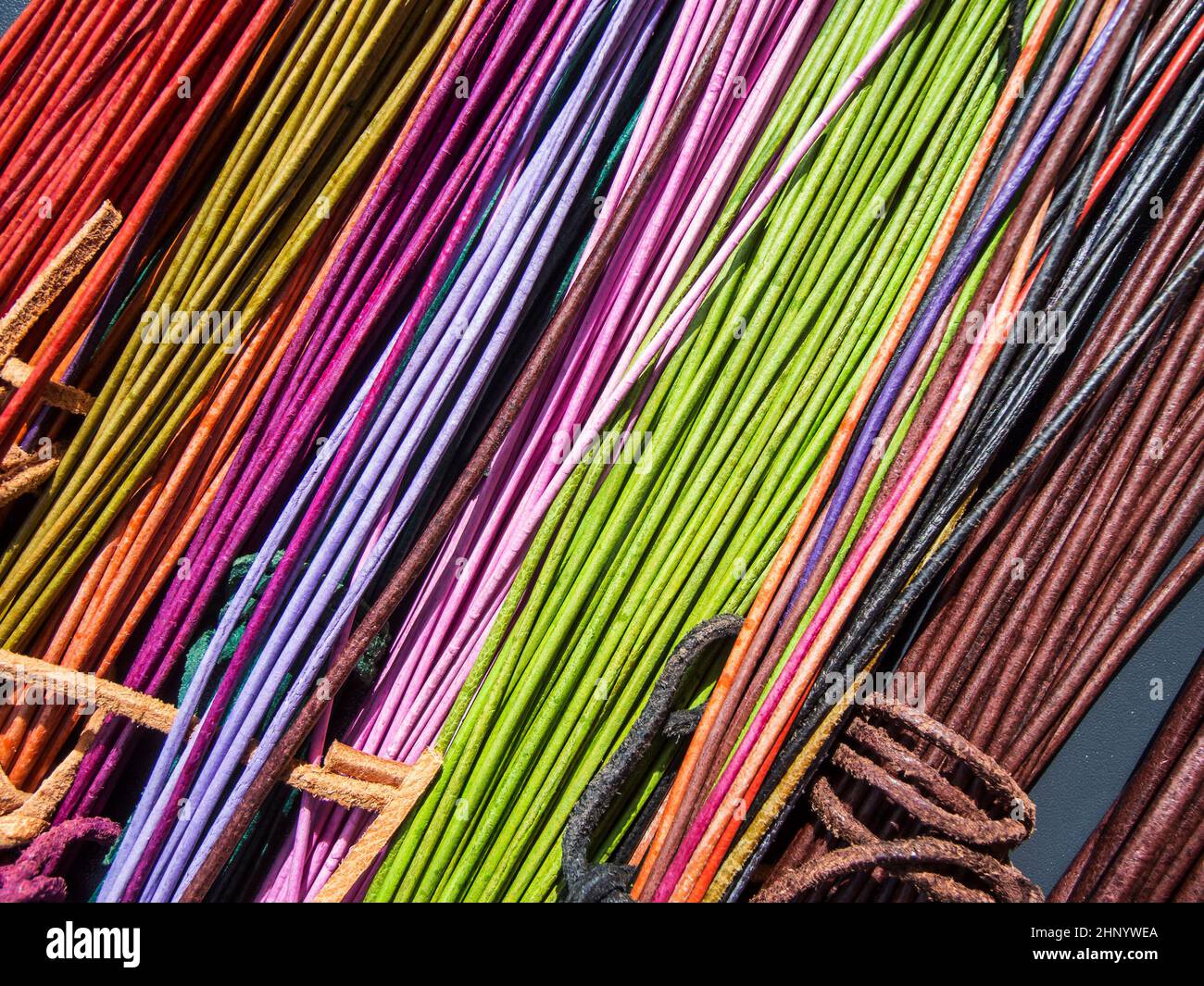 Red and orange colored leather cords with knots on a table in the ...