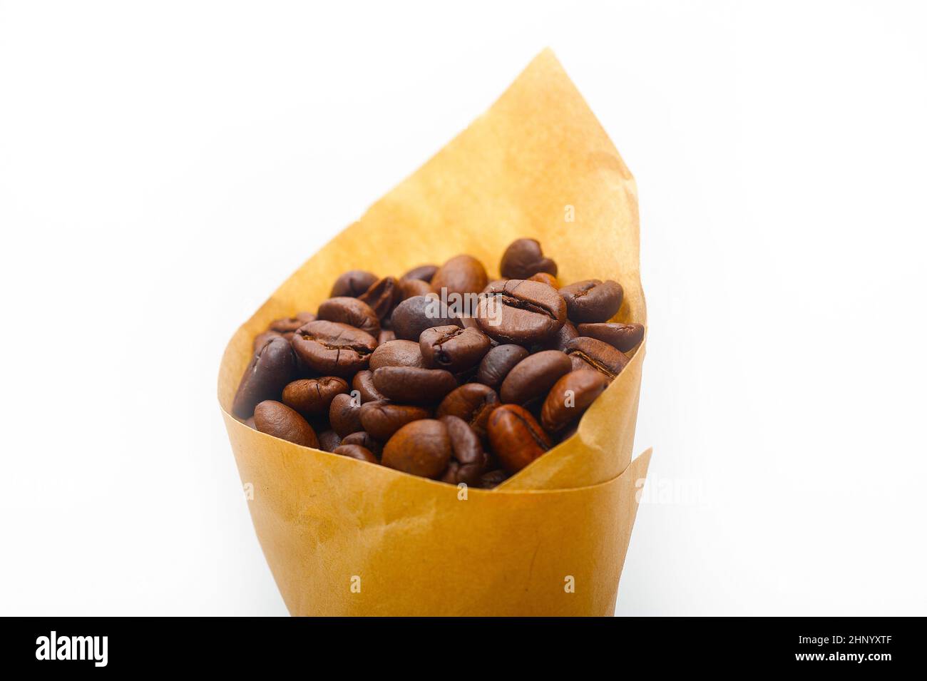 espresso coffee beans on a paper cone cornucopia over white background ...