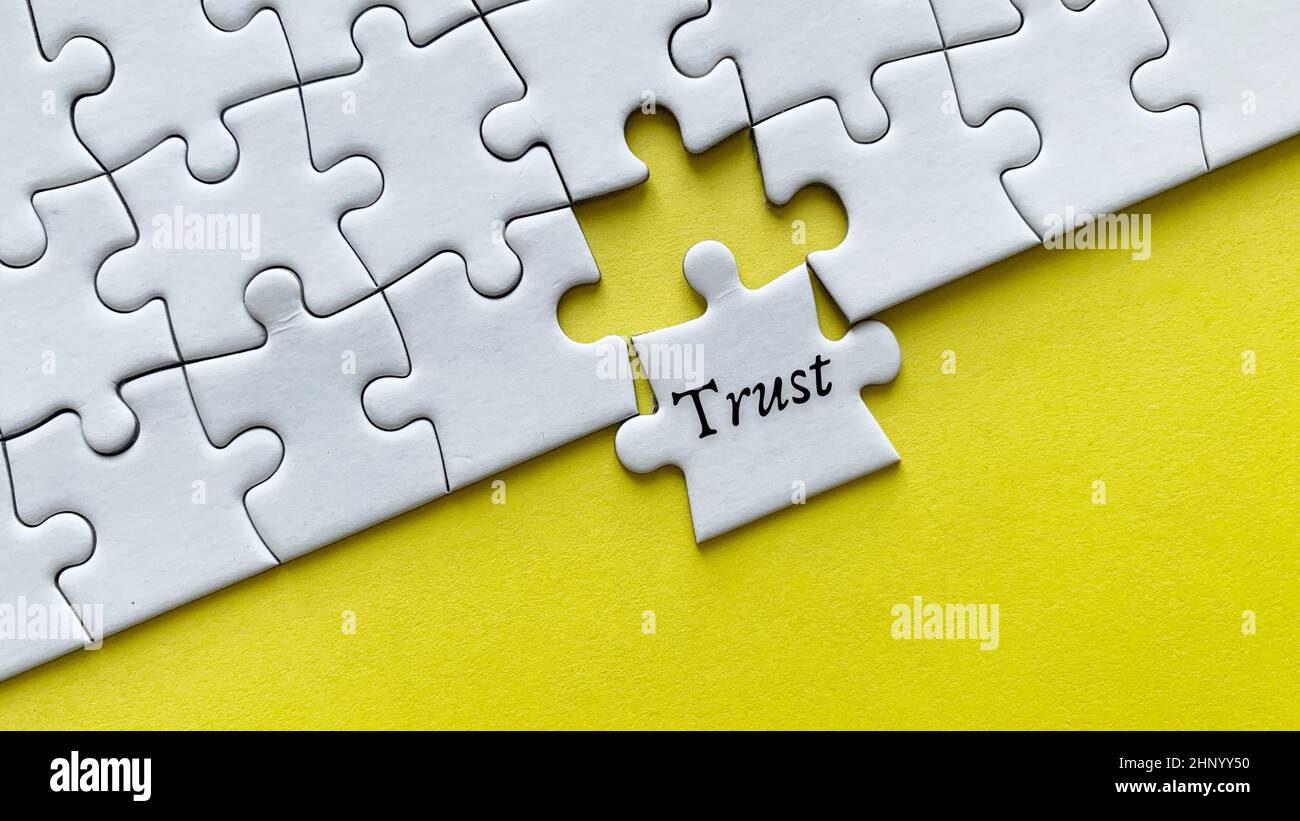 Trust word on a jigsaw puzzle with yellow background Stock Photo - Alamy