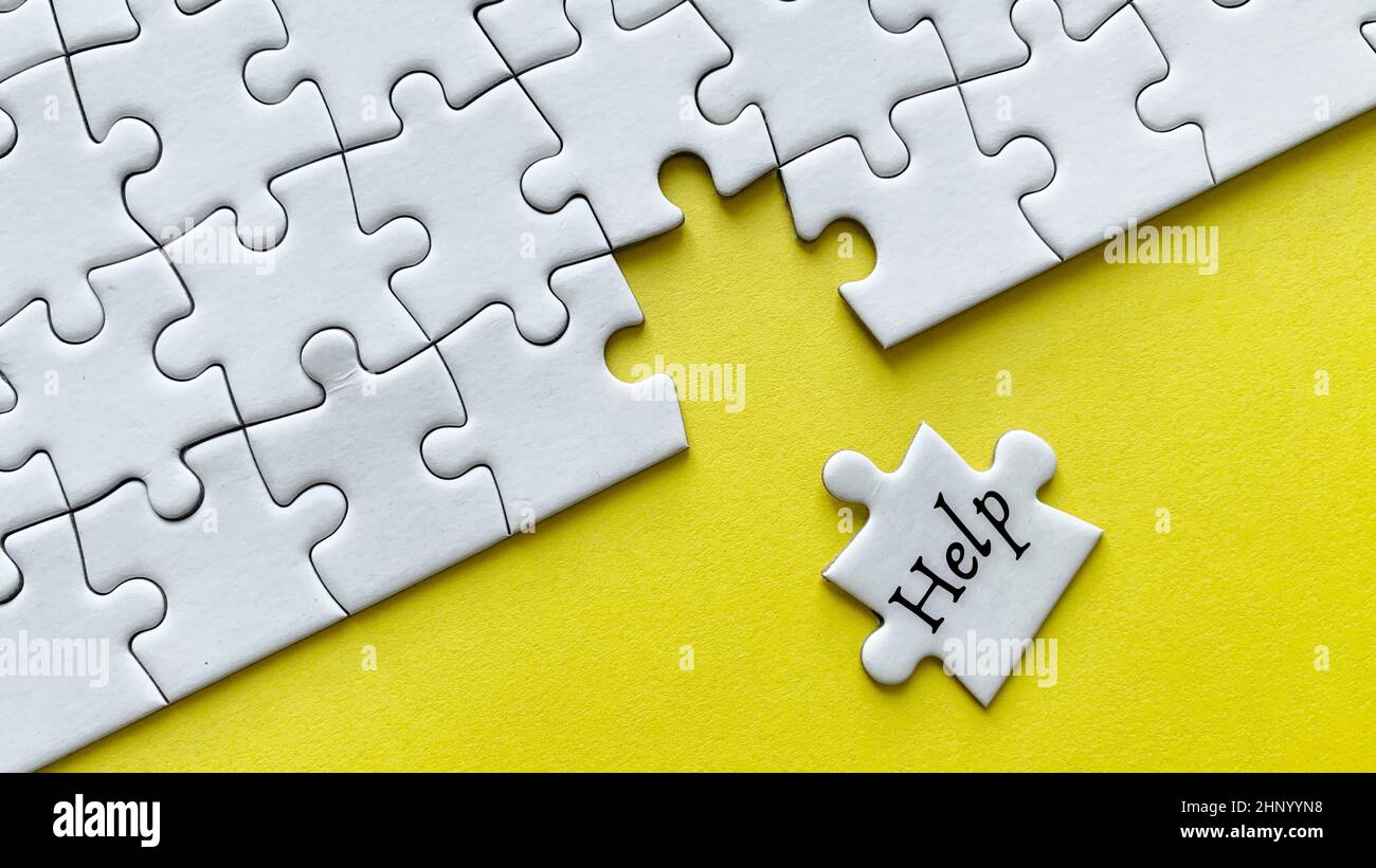 Help word on a jigsaw puzzle with yellow background Stock Photo - Alamy