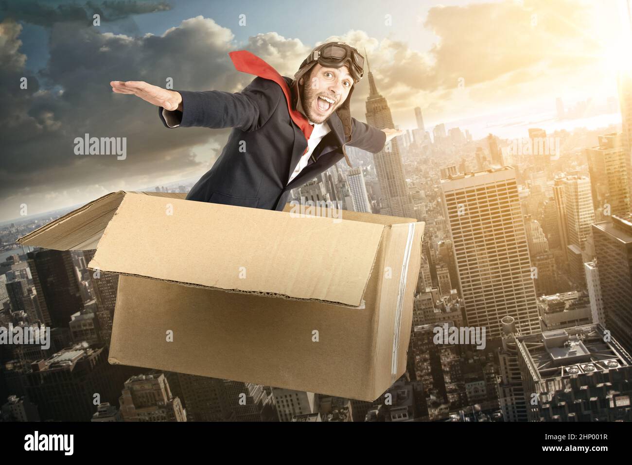 Businessman flying a carboard box over the skies Stock Photo - Alamy