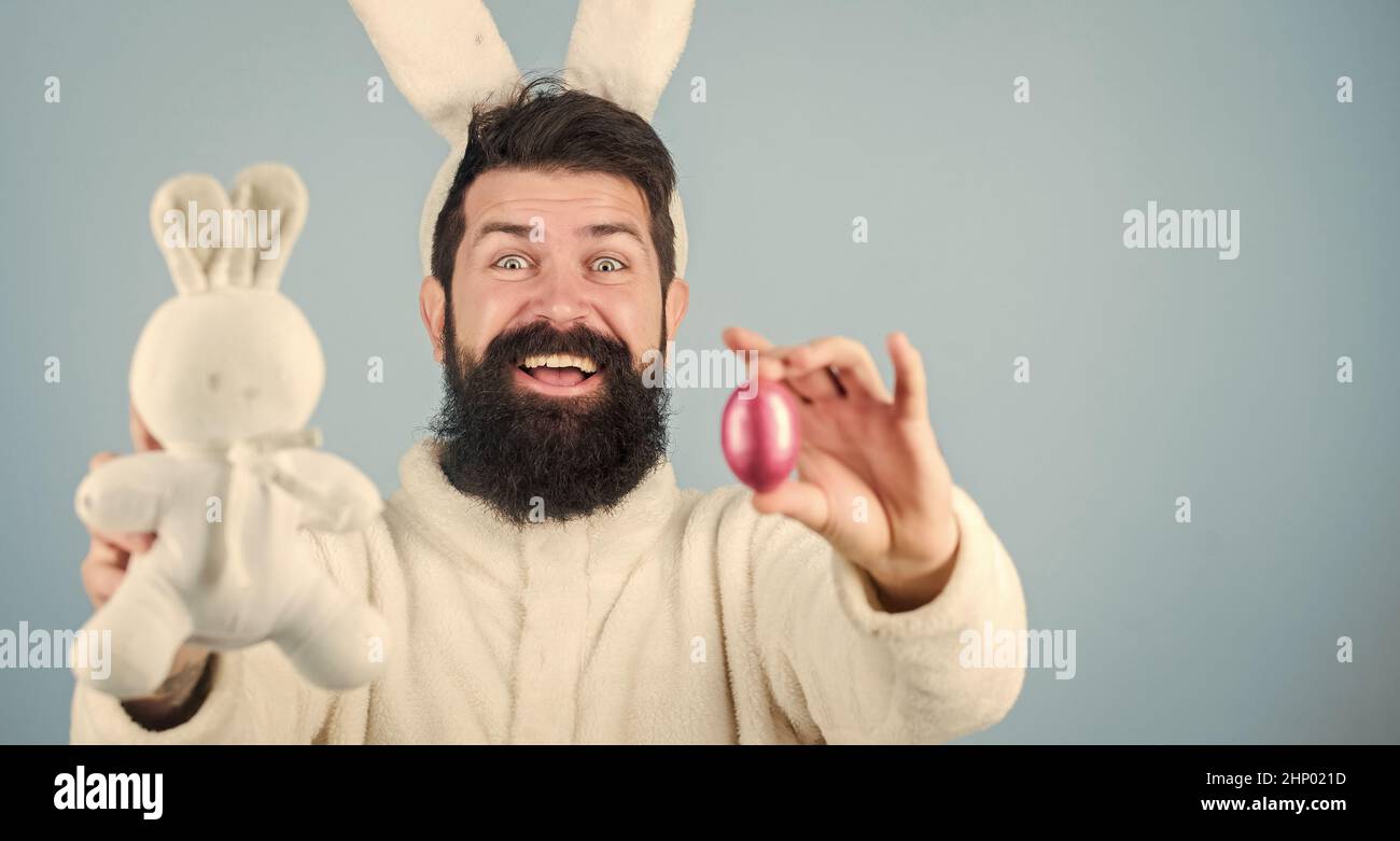 Easter symbol concept. Funny bunny with beard and mustache hold pink ...