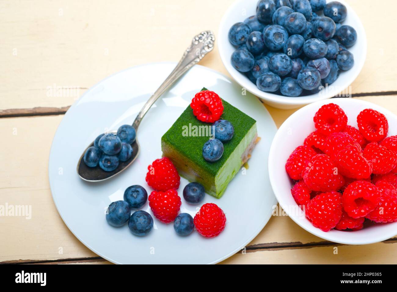 green tea matcha mousse cake with raspberries and blueberries on top ...