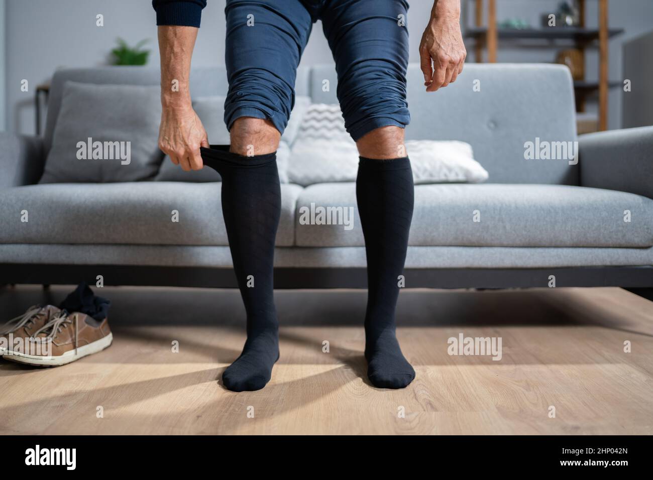 Man Putting On Medical Compression Stockings On Legs Stock Photo - Alamy