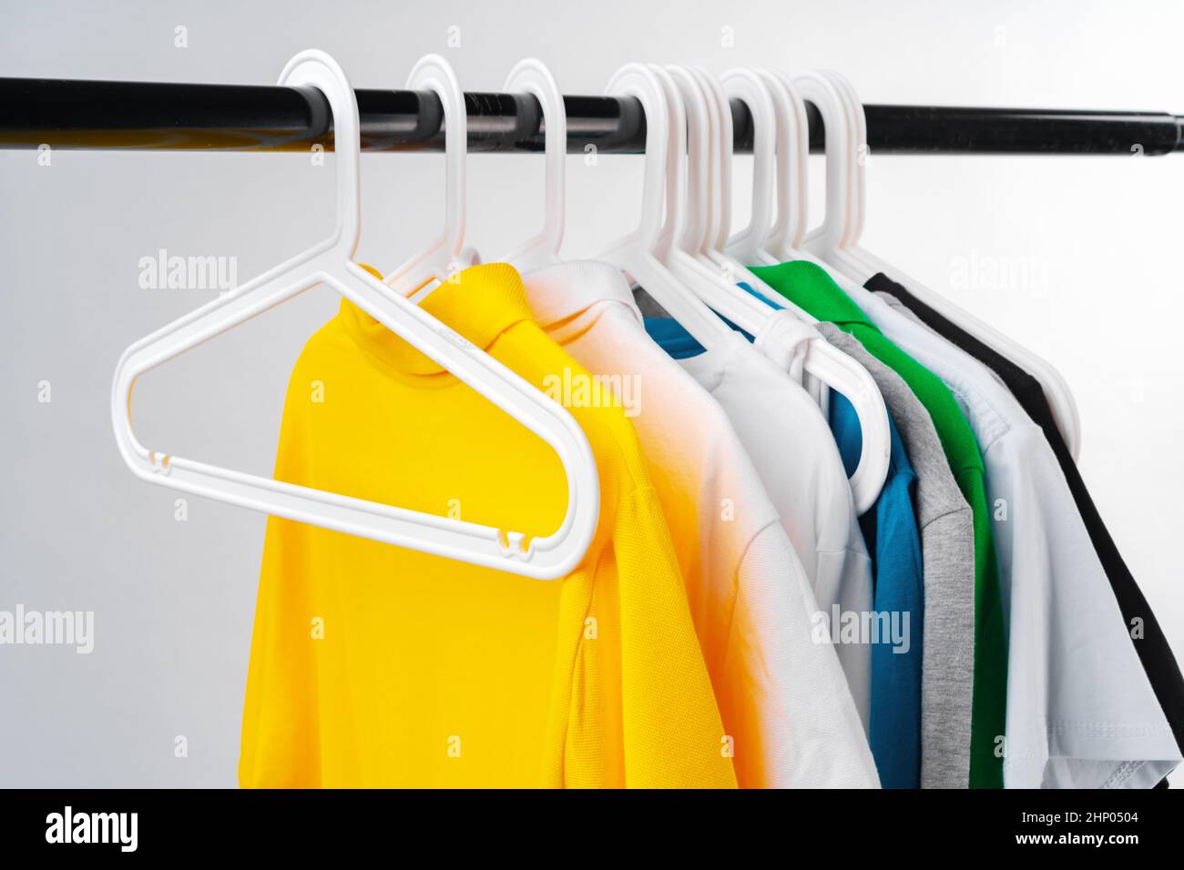 Clothes hang on clothing rack over white background Stock Photo - Alamy