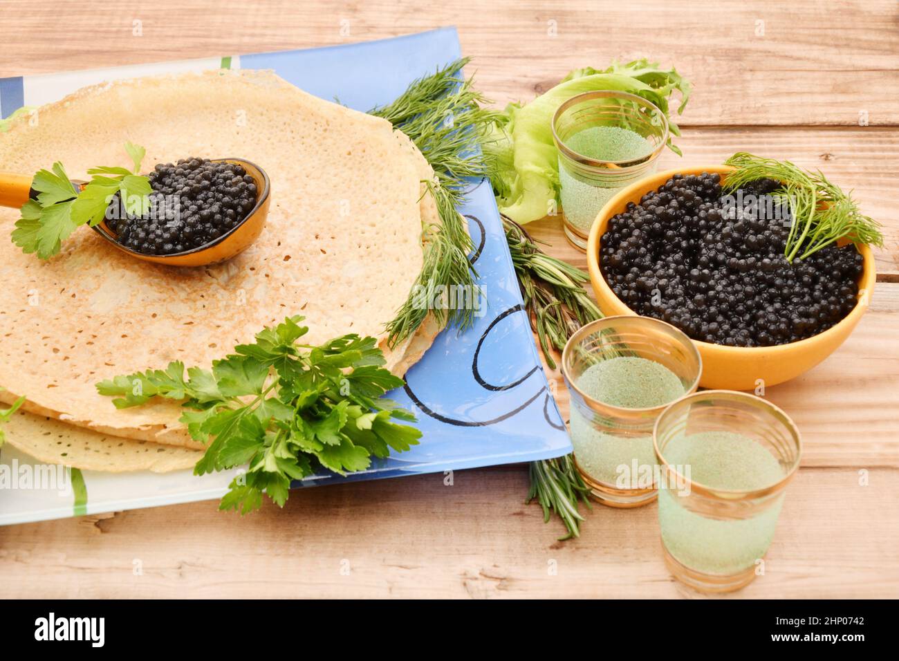 Pancakes with black caviar and fresh herbs Stock Photo - Alamy