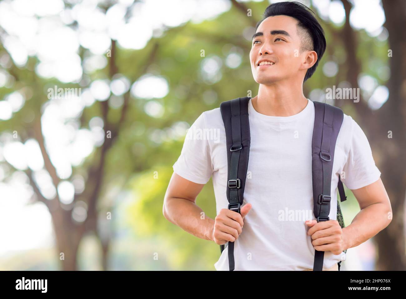Smiling handsome young man looking above Stock Photo - Alamy