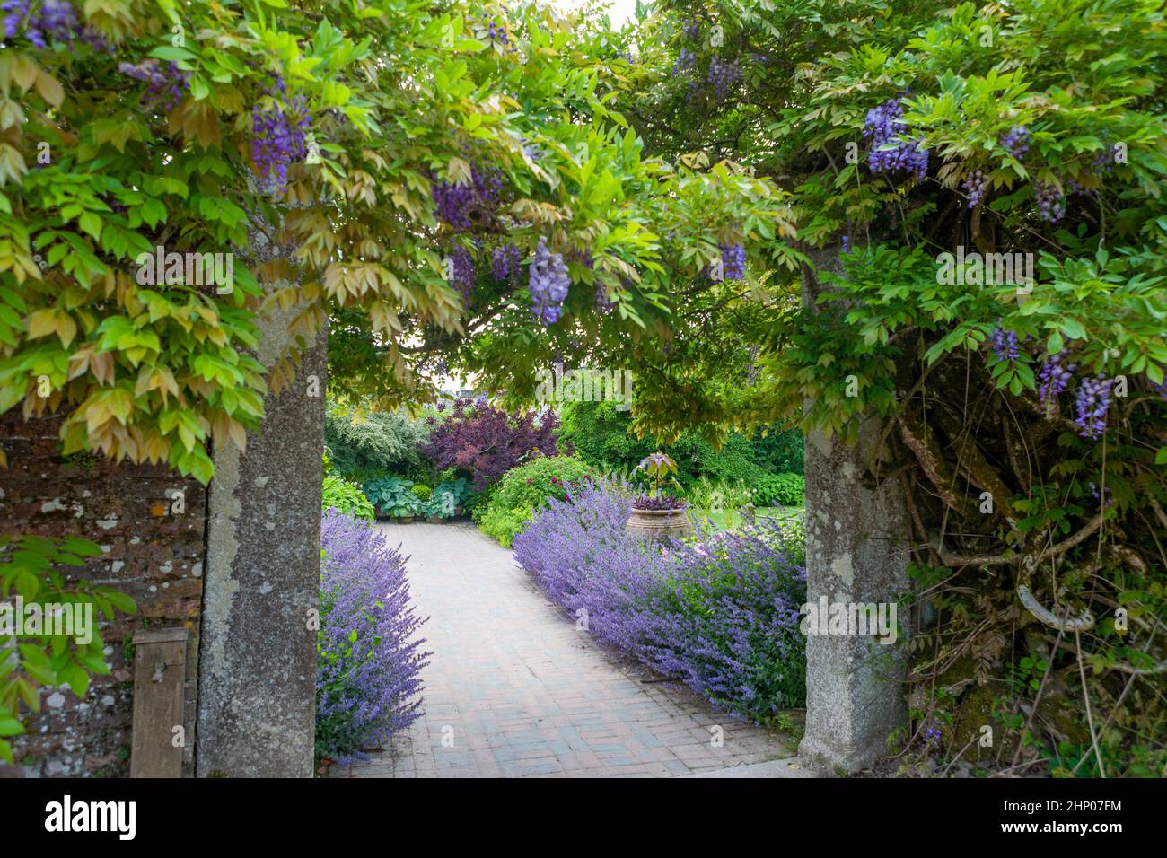 Entering the Sundial Garden through stone pillars festooned with ...