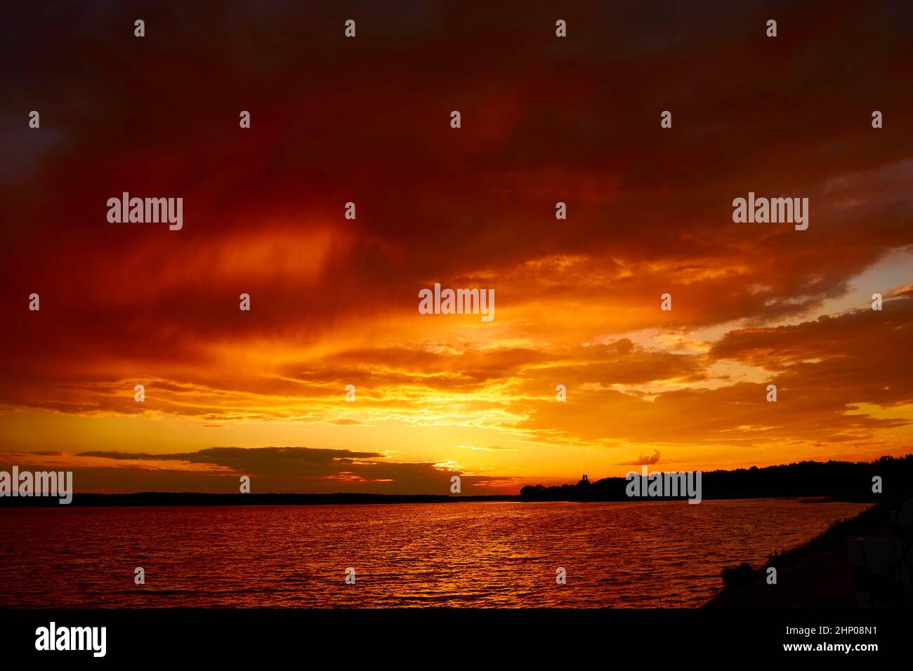 Red cloudy sunset above lake at dusk. Bloody sky above reflective water ... Red cloudy sunset above lake at dusk. Bloody sky above reflective water ...