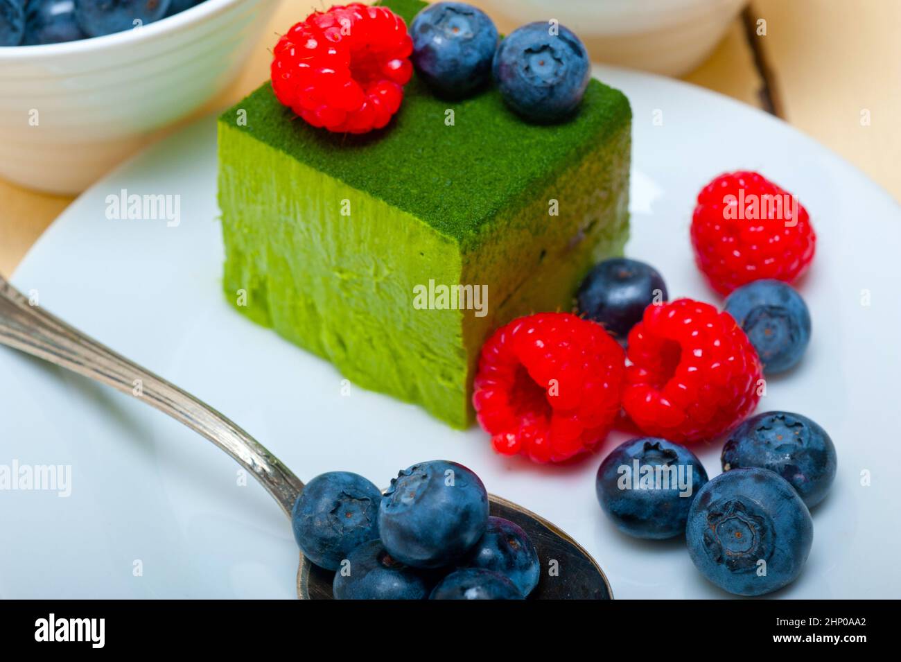 green tea matcha mousse cake with raspberries and blueberries on top ...