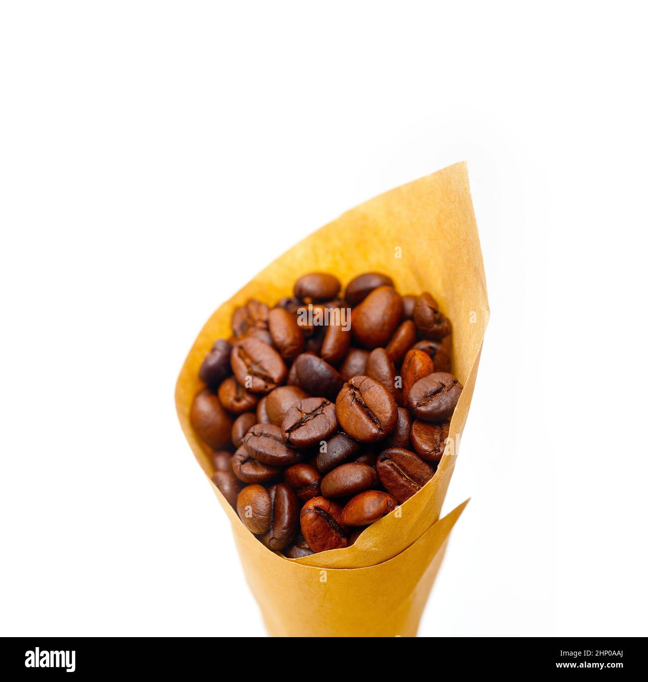 espresso coffee beans on a paper cone cornucopia over white background ...