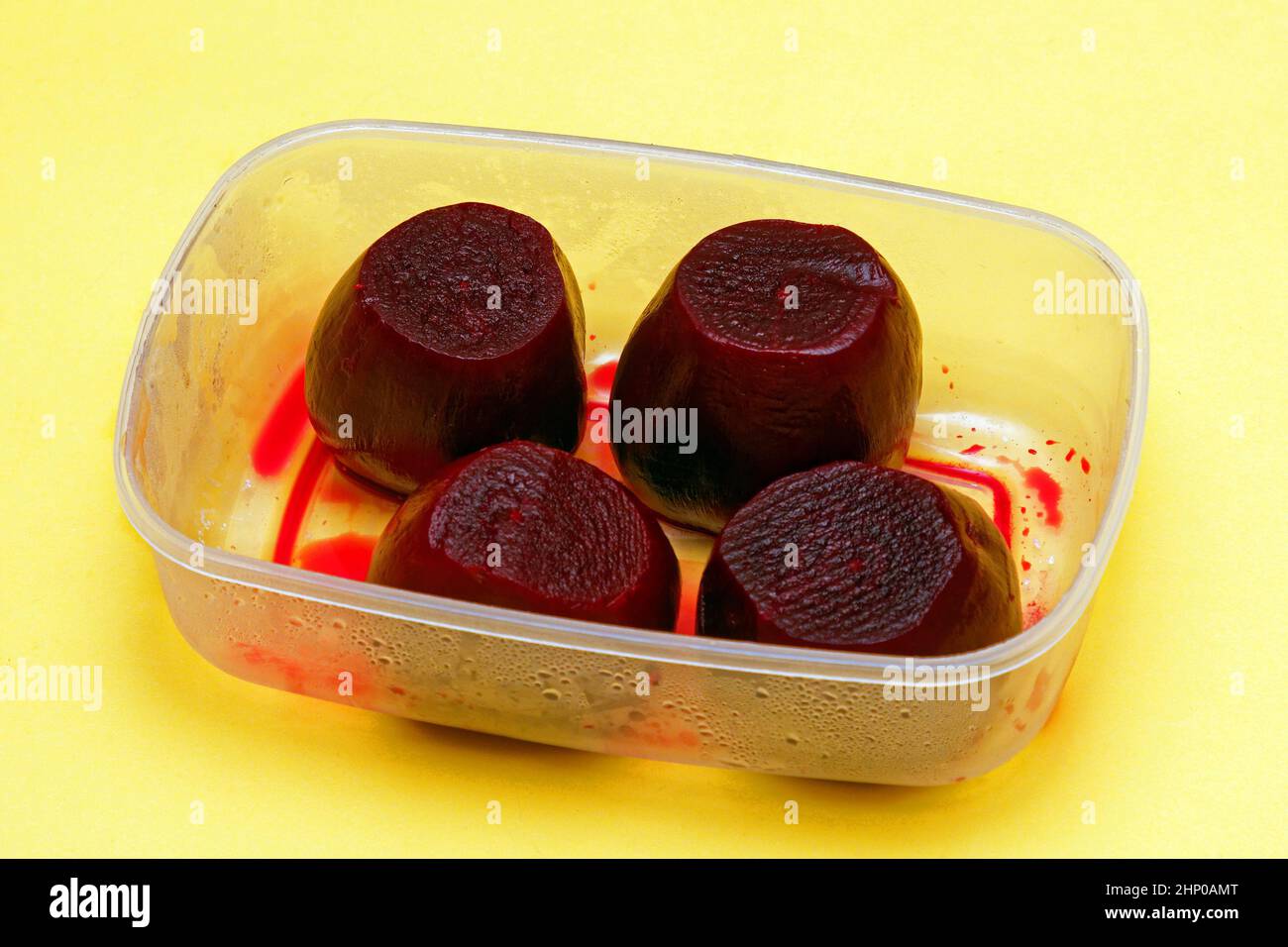 Cooked and peeled beetroot in plastic box on yellow background Stock ...
