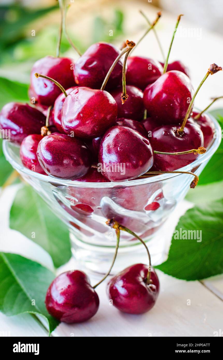 Ripe and fresh burgundy cherries in a glass vase and a jar for healthy ...
