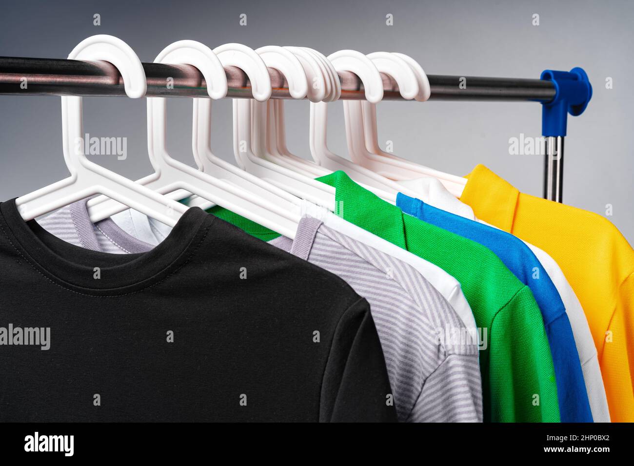 Clothes hang on clothing rack over white background Stock Photo - Alamy