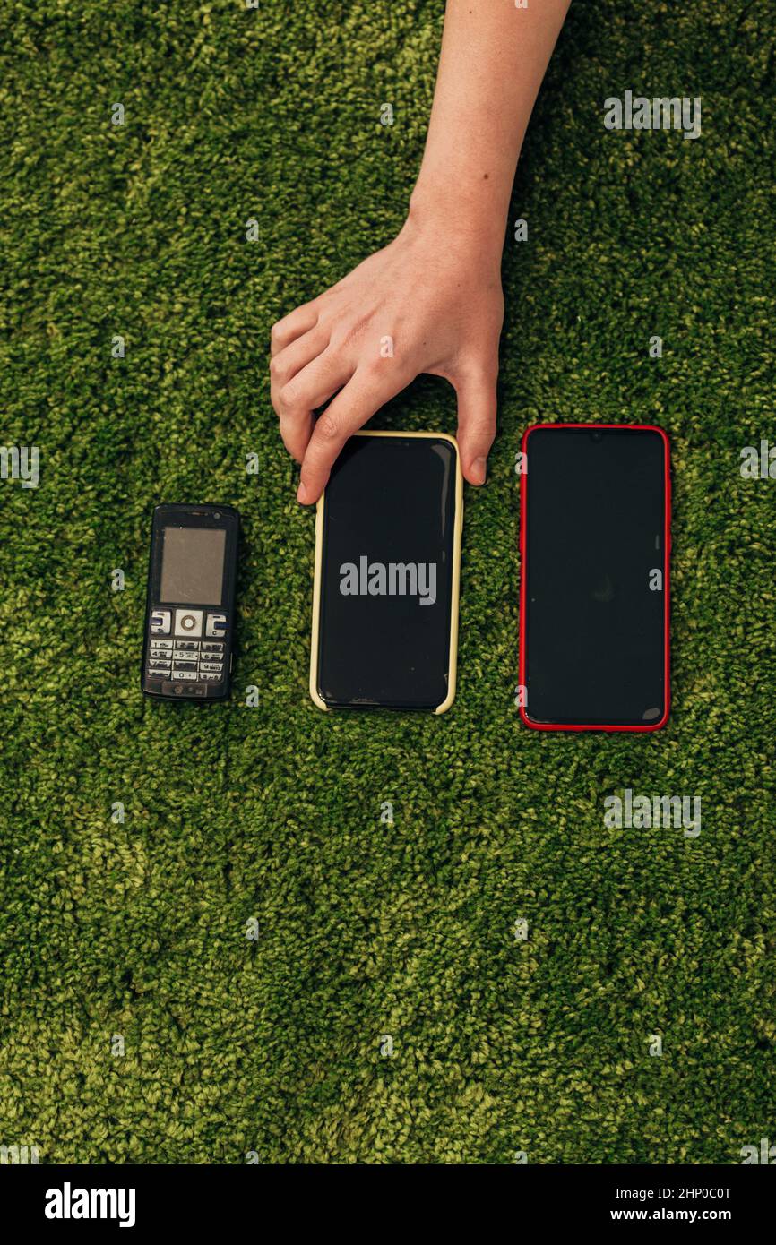 The Human Hand Choosing Phone That Lies Near New Smartphones Stock ...