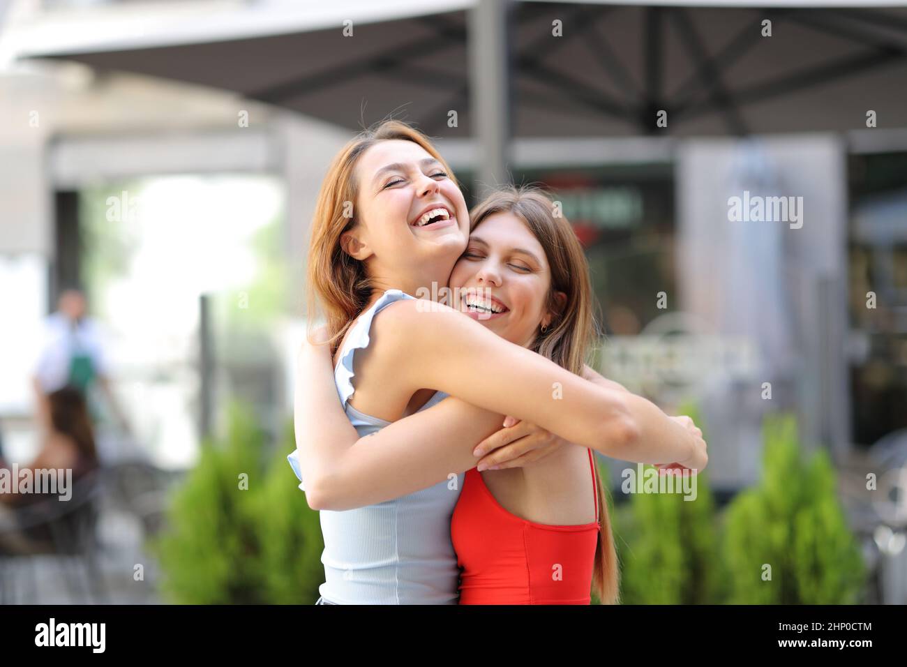 Two funny friends meeting laughing and embracing in the street Stock ...
