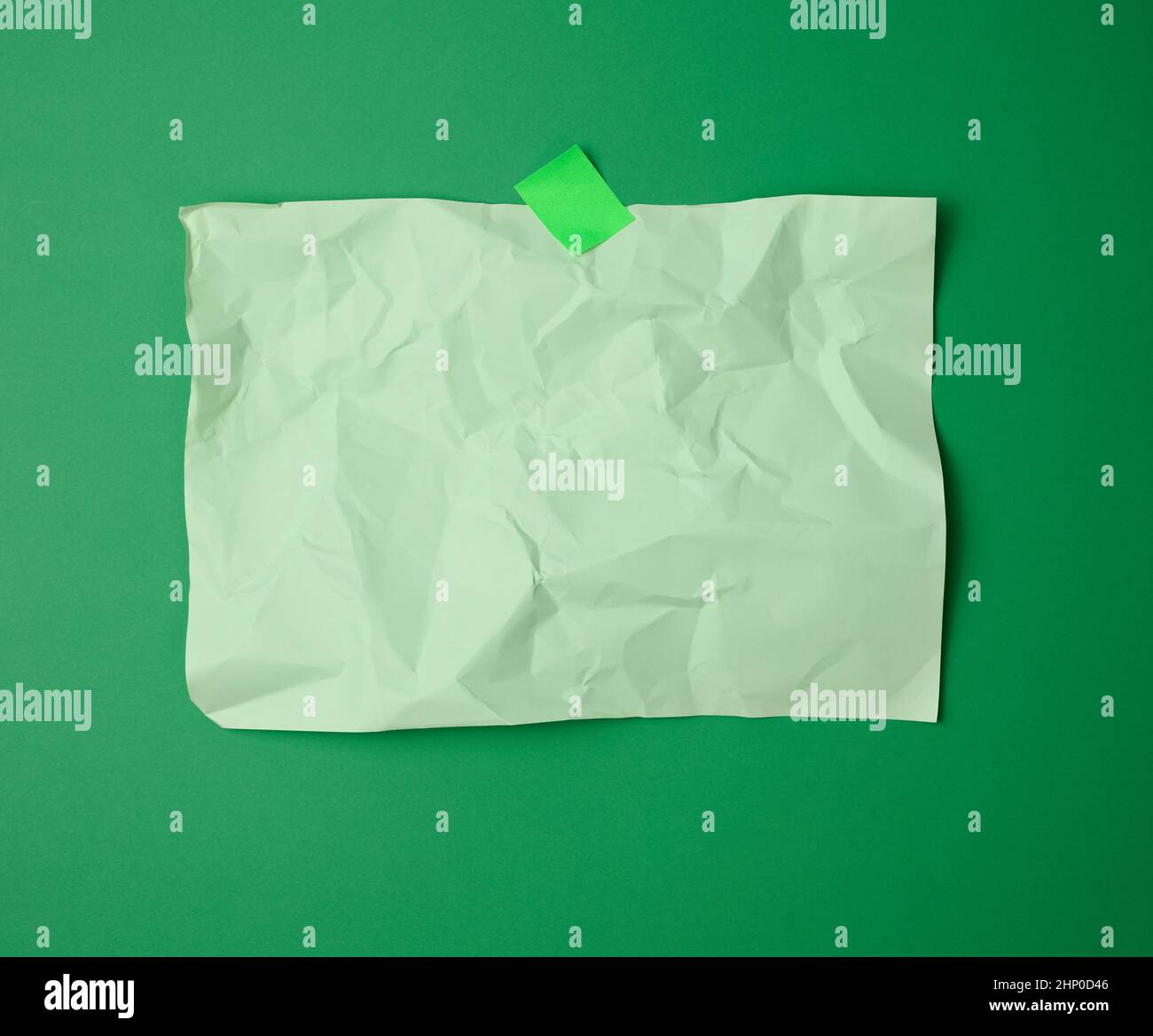 rectangular crumpled blank green sheet of paper glued with green sticky ...