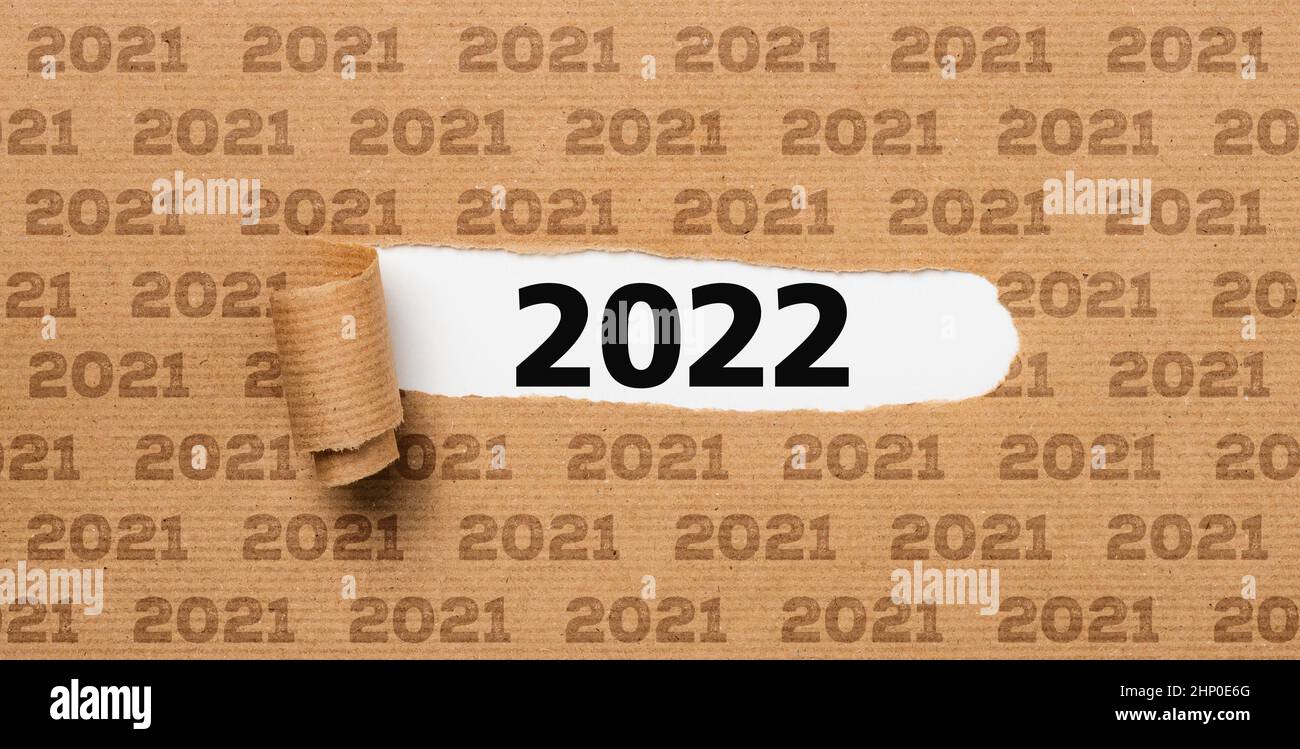 Torn paper revealing the number 2022 Stock Photo - Alamy