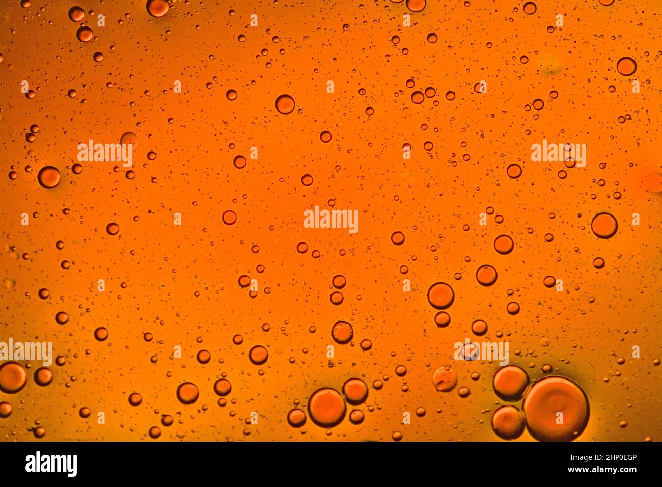close-up view of a deep orange liquid background of moving bubbles ...