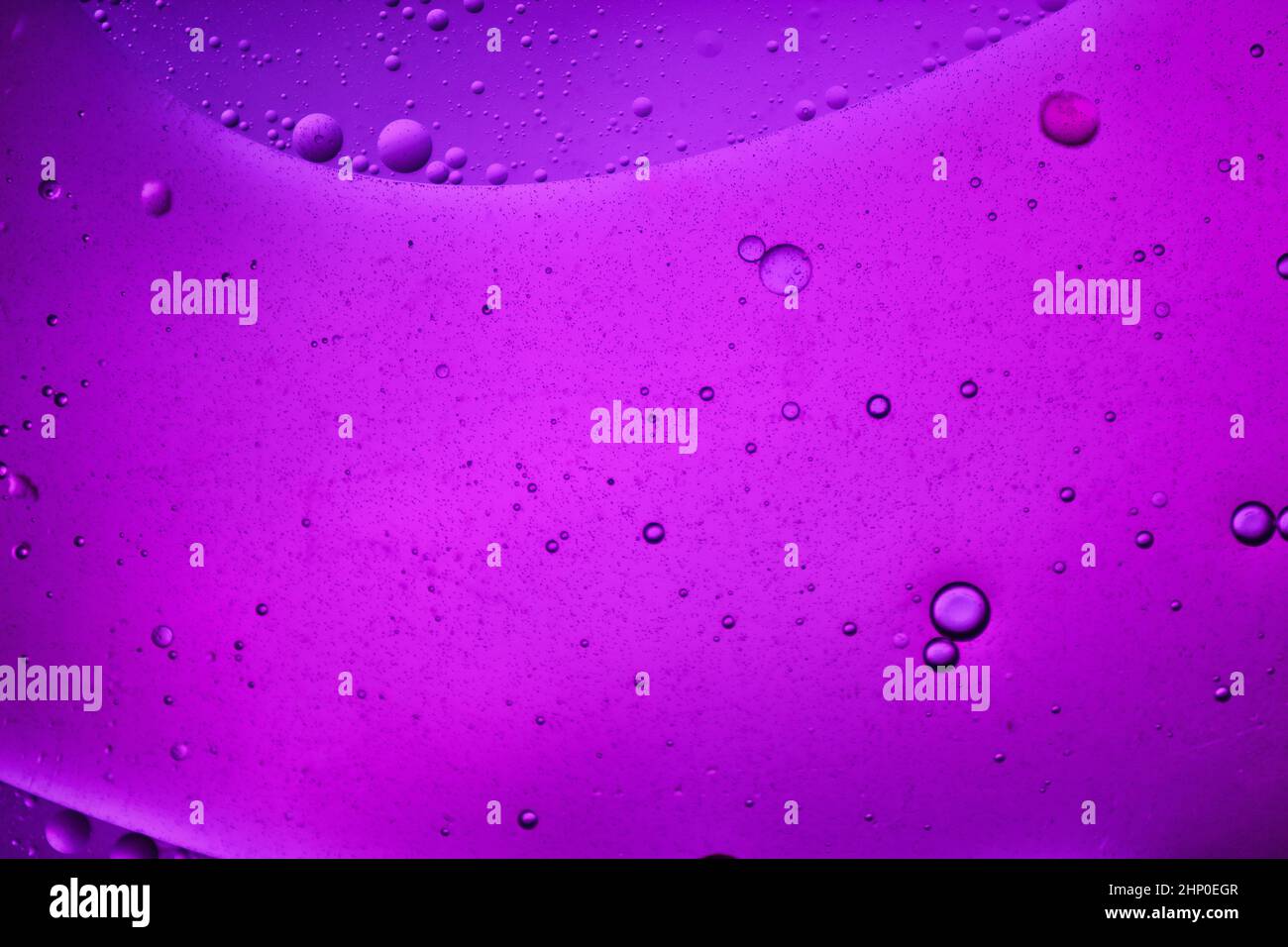 close-up view of a loose purple liquid background of moving bubbles ...