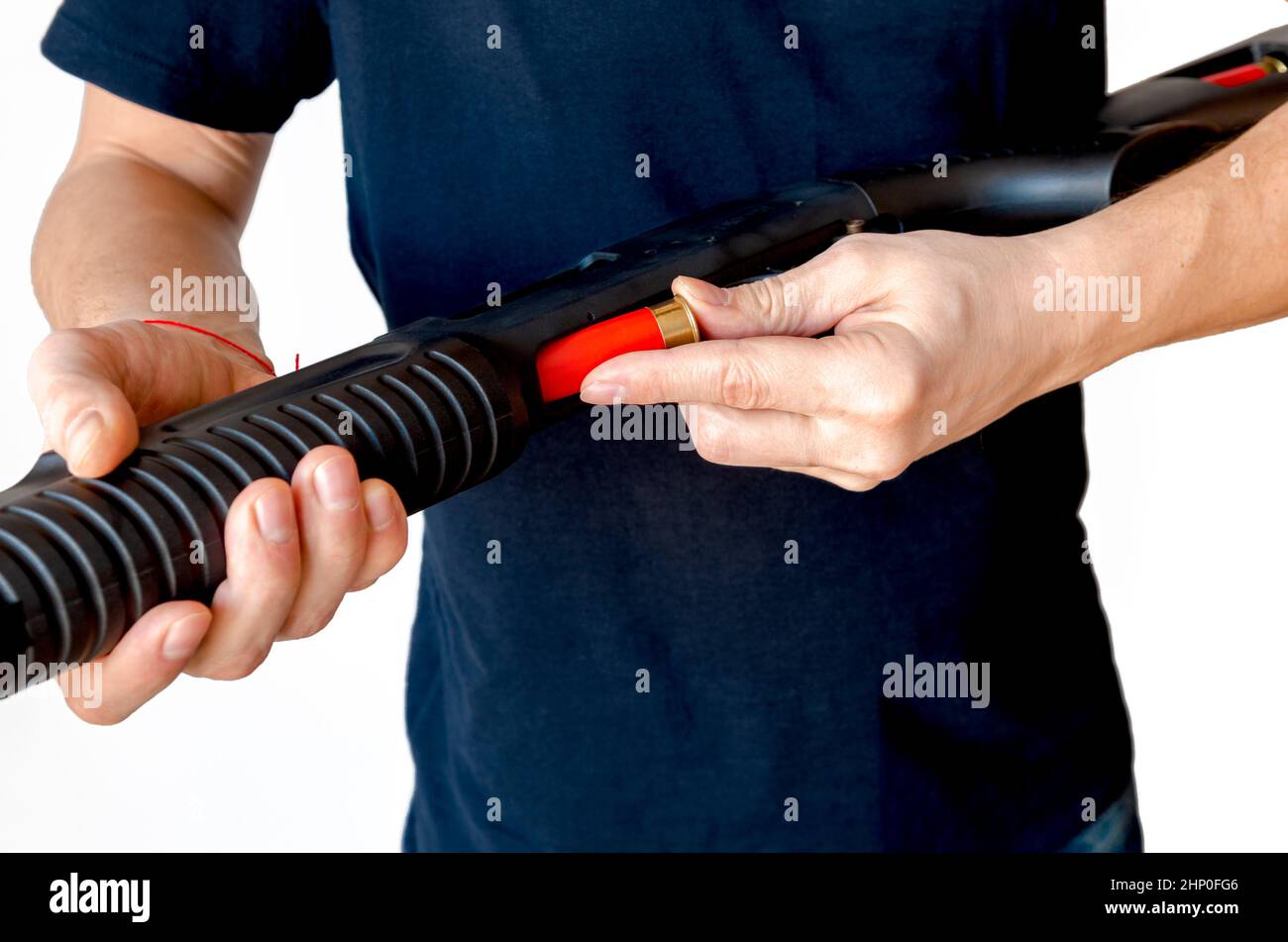 Close up of man loading a red shotgun shell into the magazine of his ...
