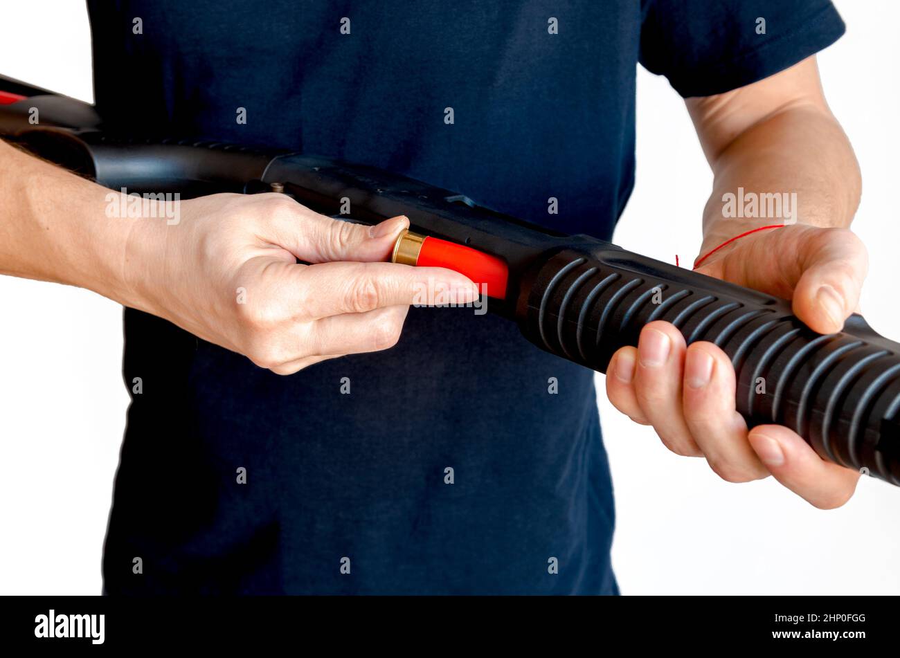 Close up of man loading a red shotgun shell into the magazine of his ...