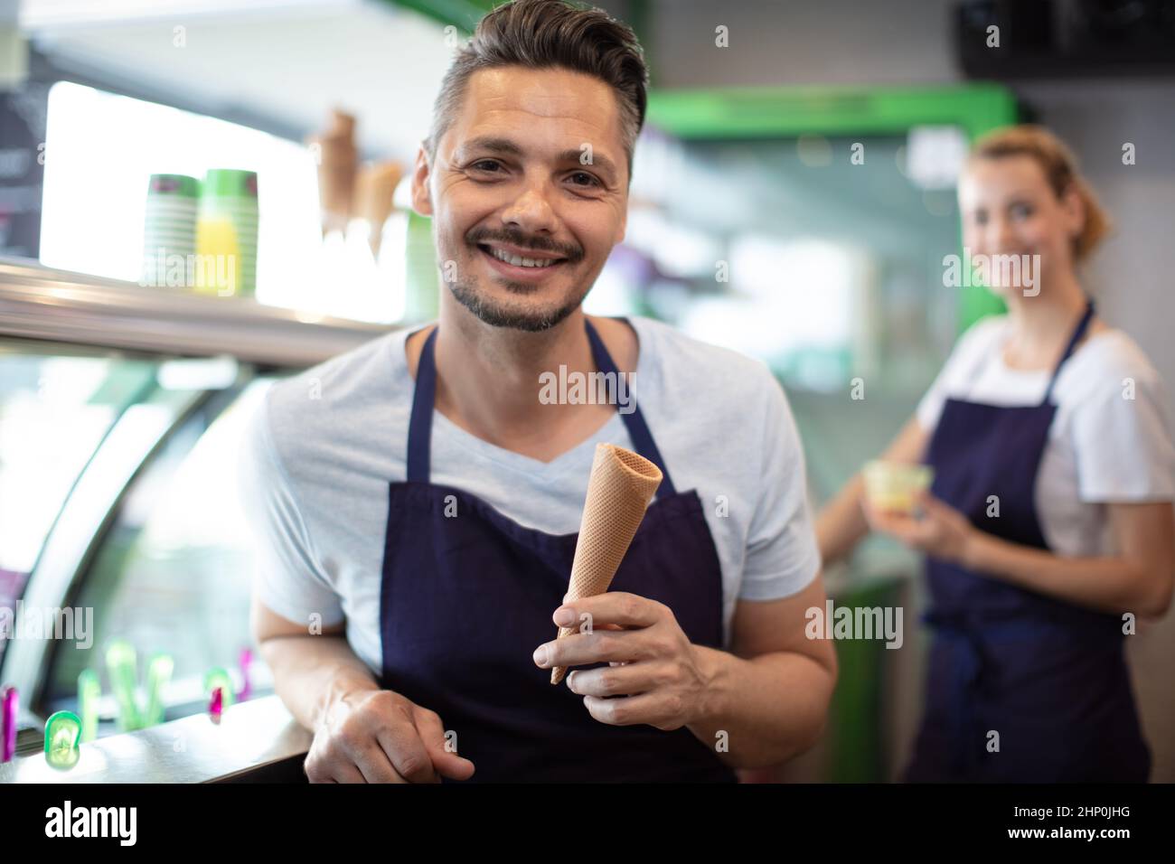 worker working with coworker at counter in ice cream parlor Stock Photo ...