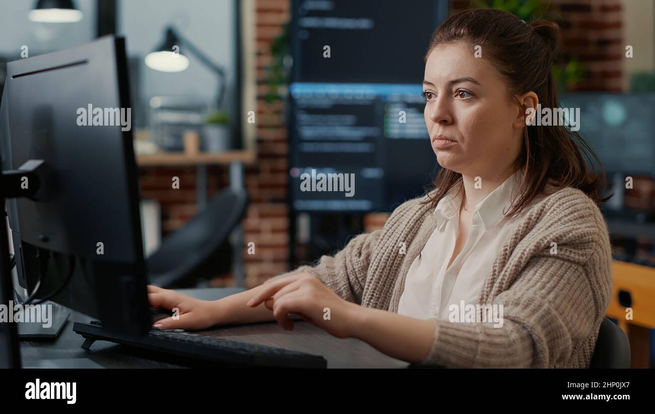 Caucasian system engineer working focused looking at computer screen while typing in big data ...