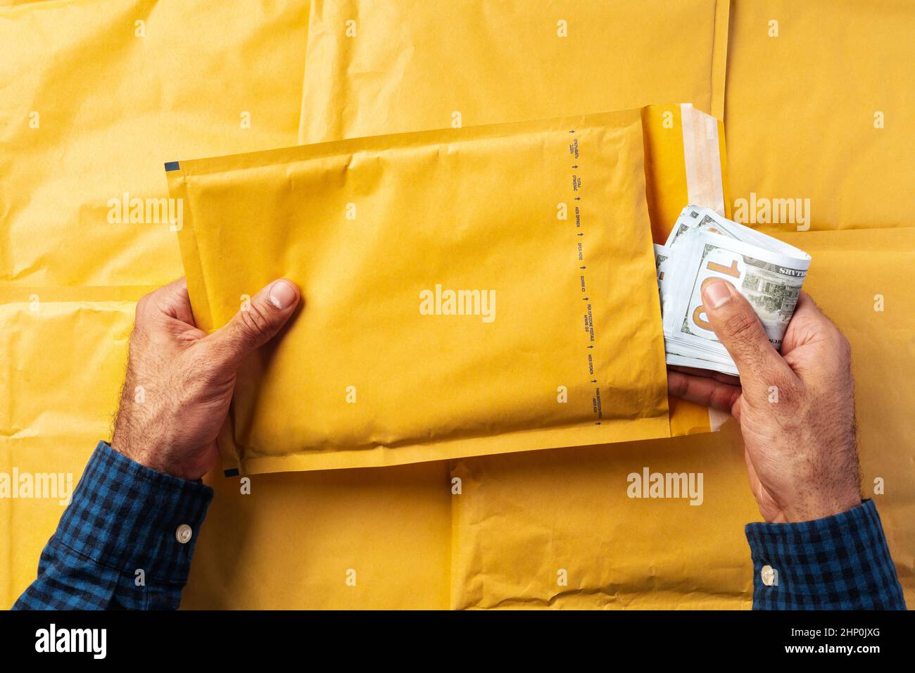 Male hands packing money in bubble envelopes for shipping Stock Photo ...
