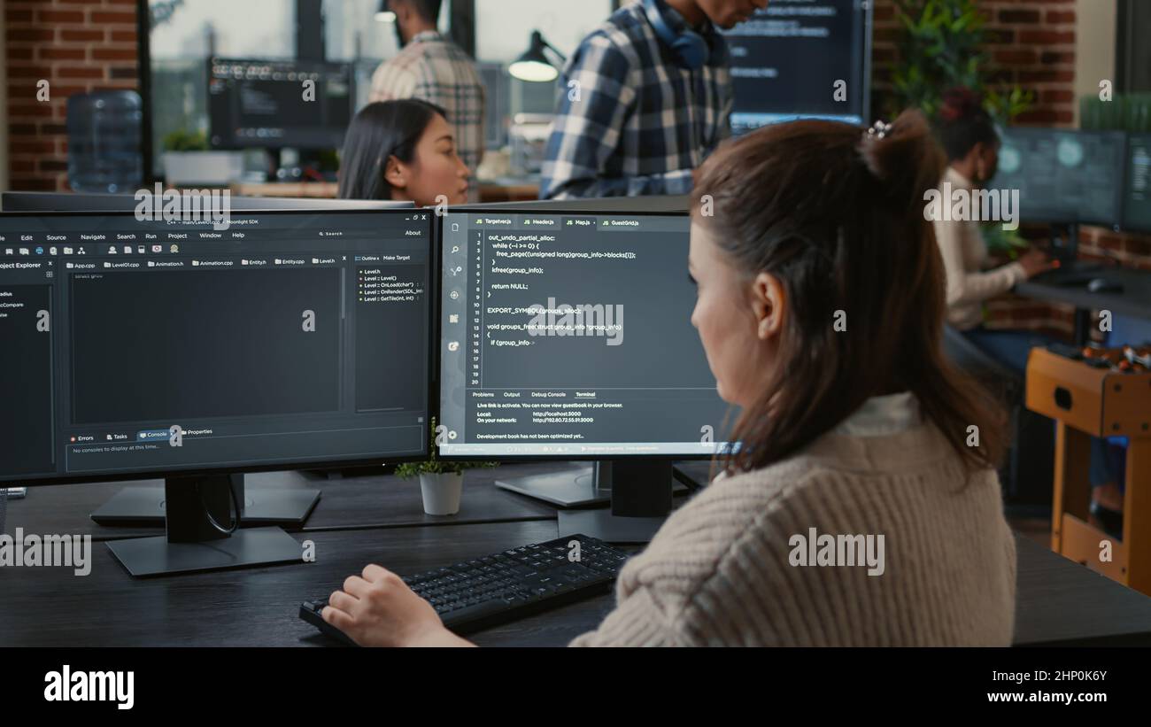Software Programer Writing Code In Front Of Multiple Computer Screens Displaying Artificial