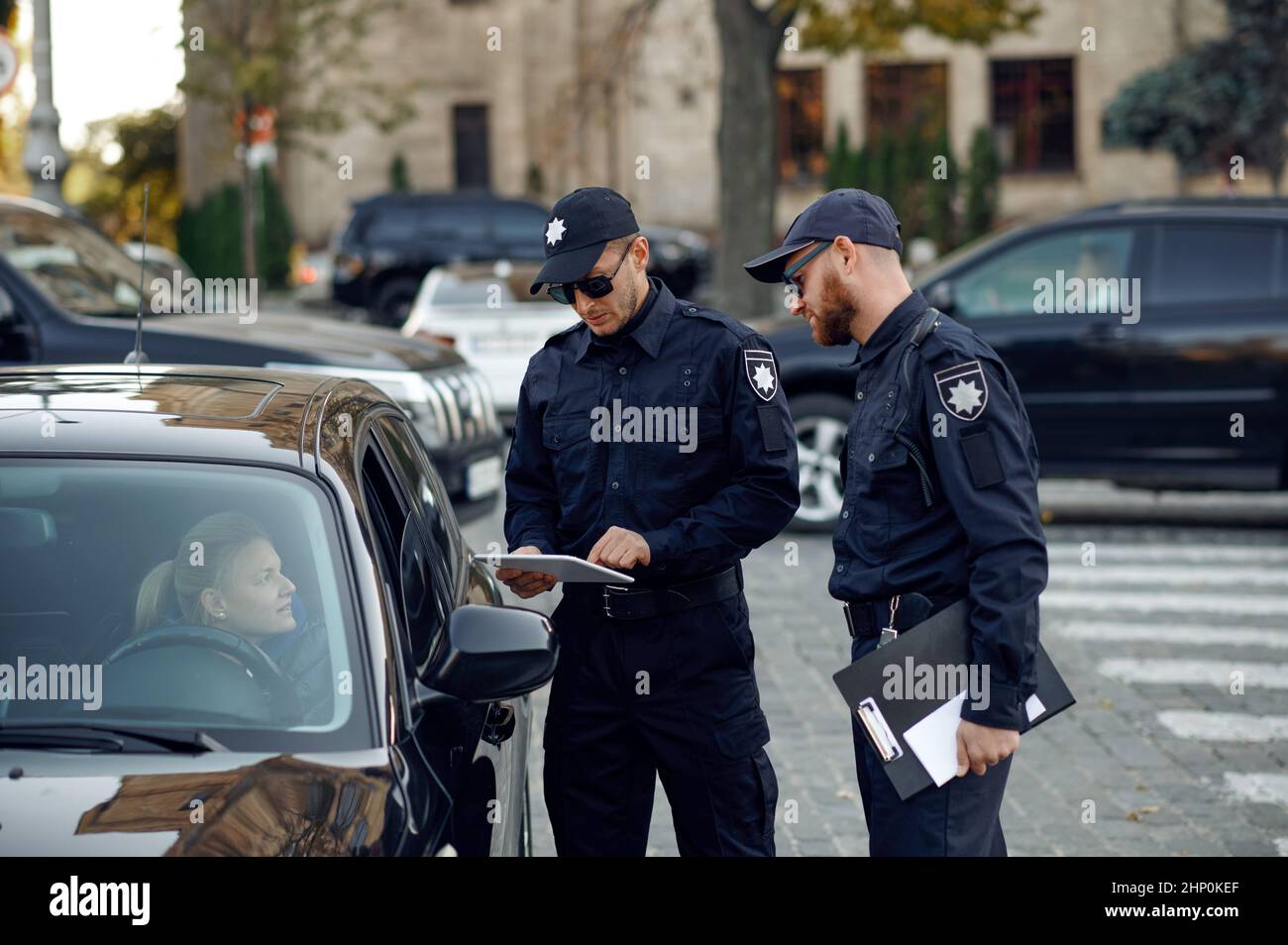 Two male police officers checking the driver's license. Policemen in ...