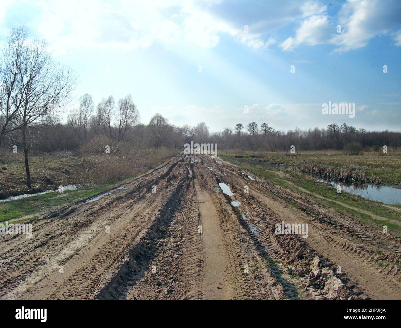 Road with puddles and mud after rain. Dirt and traces of protectors of ...