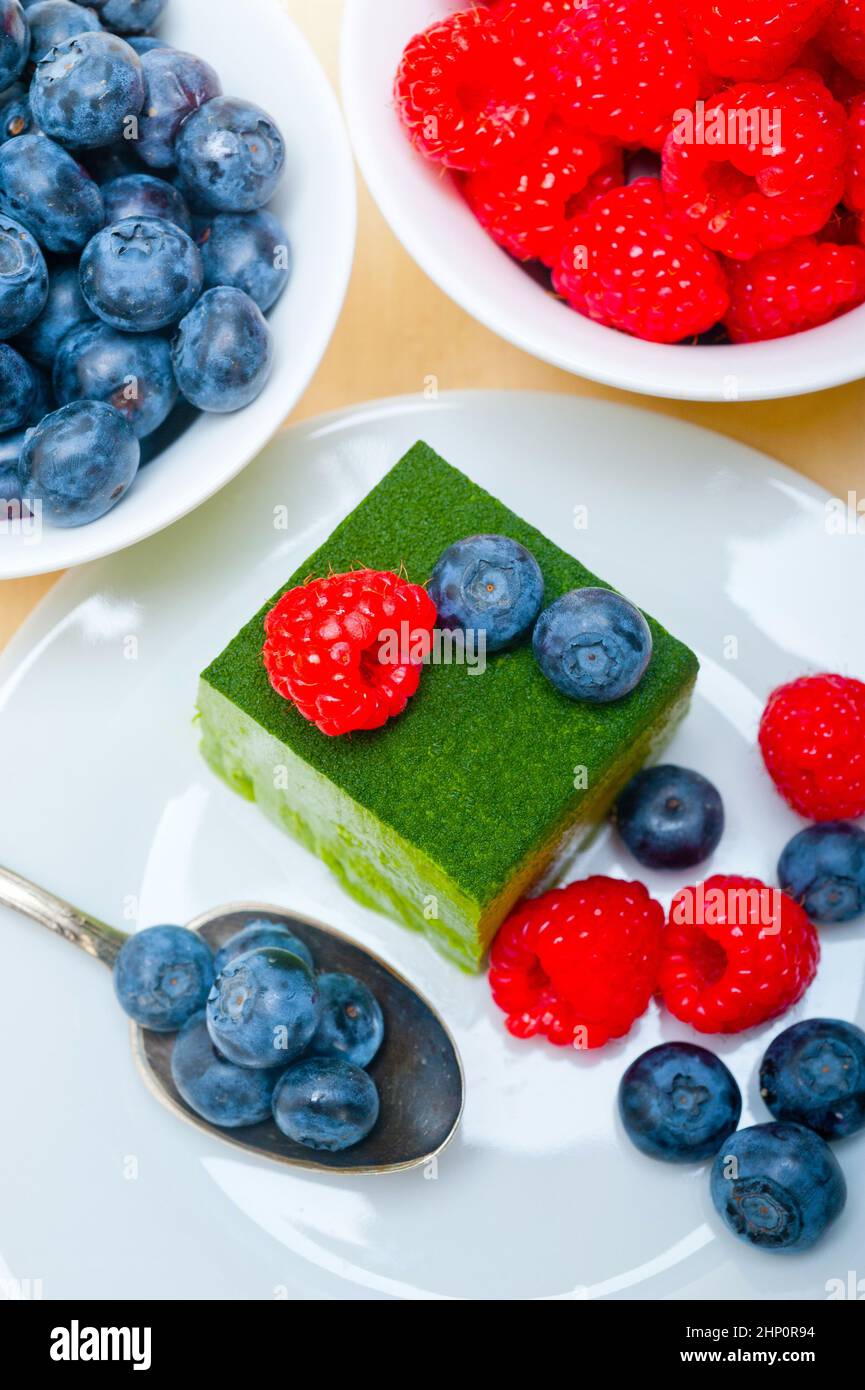 green tea matcha mousse cake with raspberries and blueberries on top ...