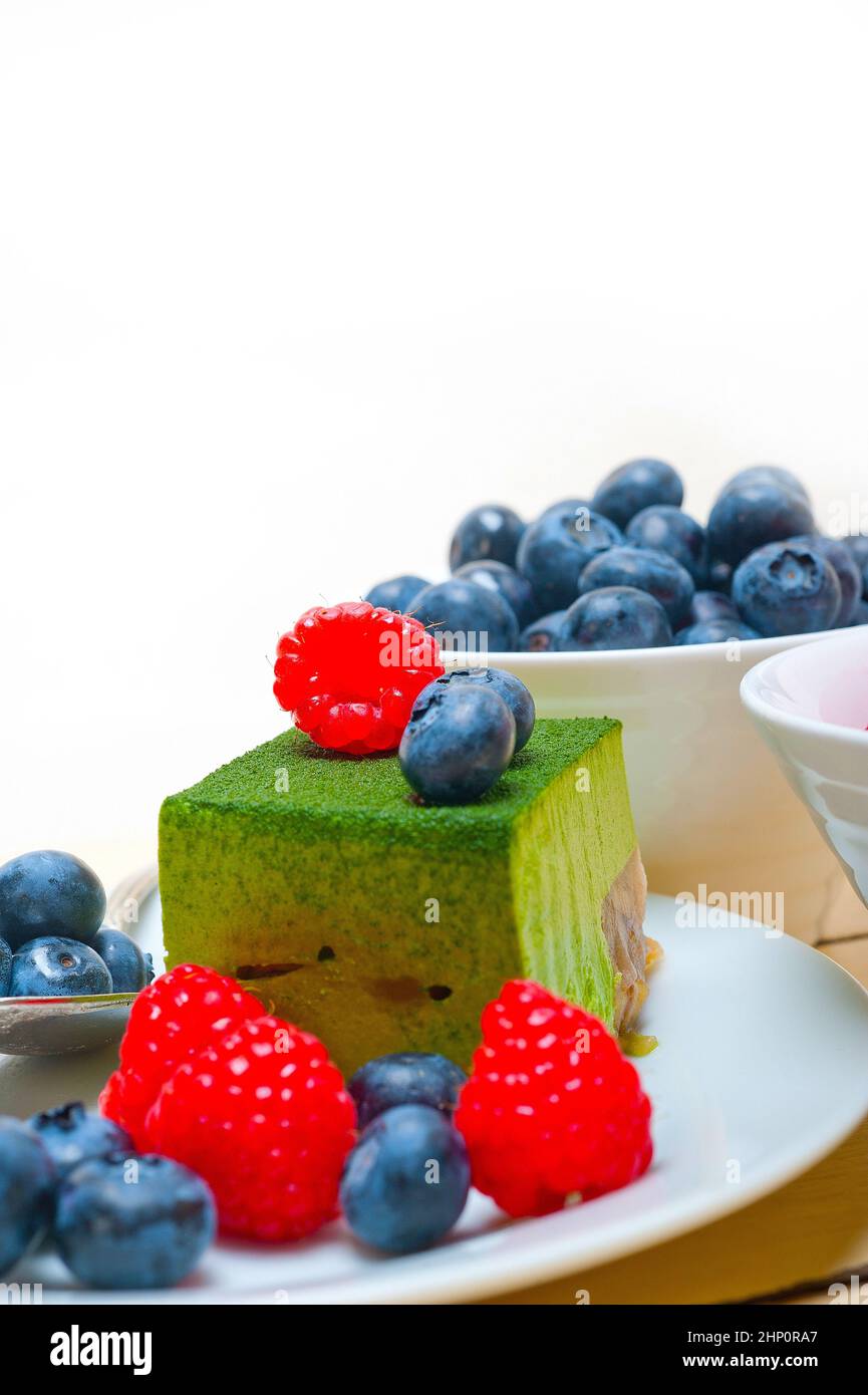 green tea matcha mousse cake with raspberries and blueberries on top ...