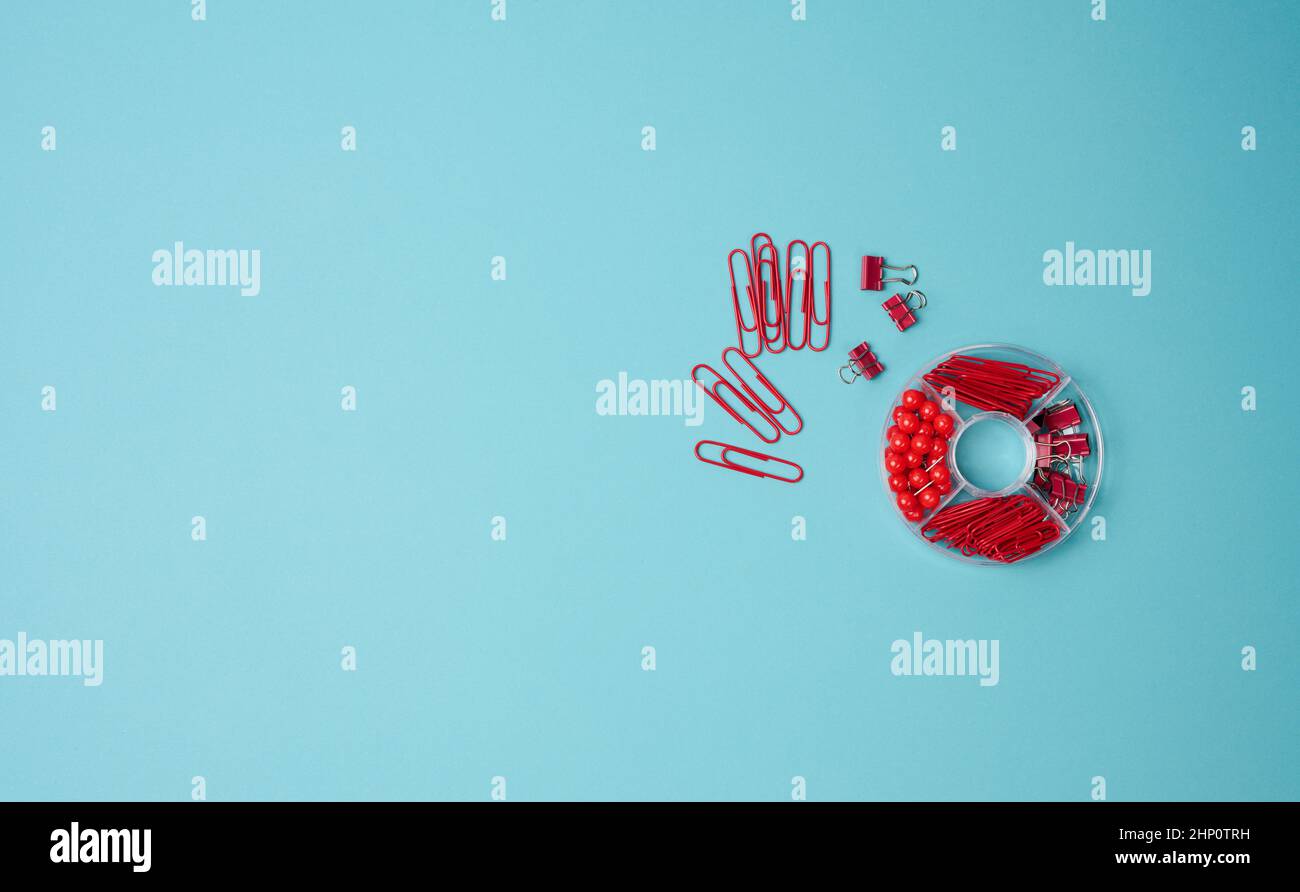 set of stationery objects: paper clip, buttons and clip on a blue ...