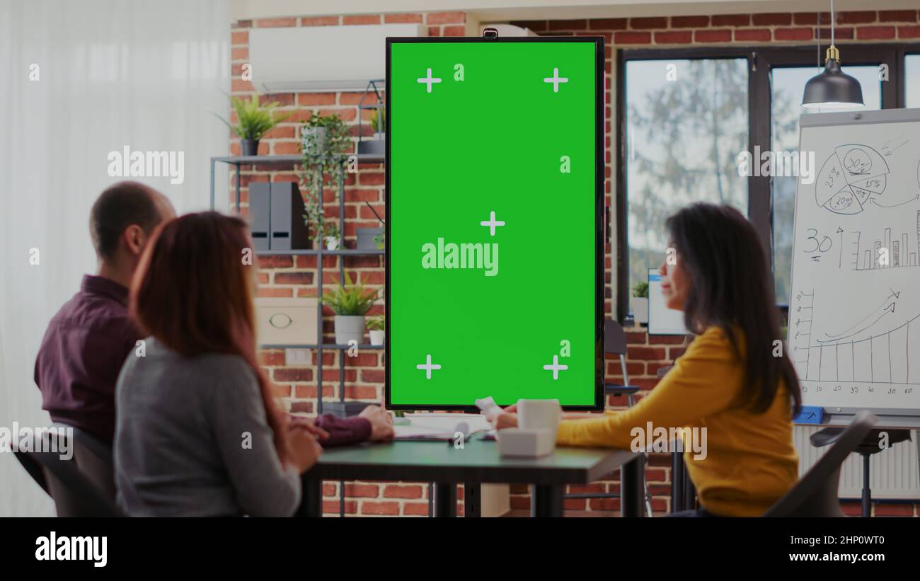 Employees using green screen on monitor vertically in boardroom ...