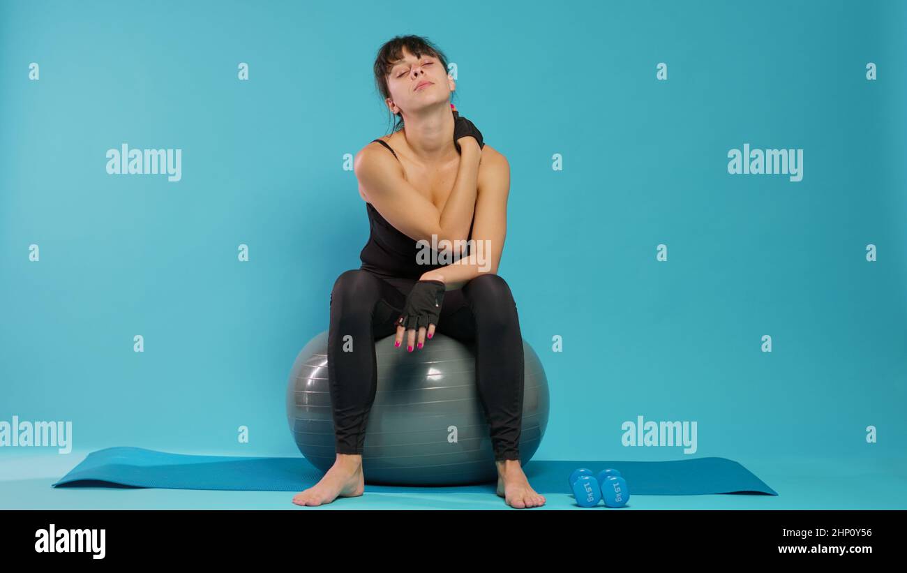 Tired woman taking break and breathing after intense workout practice ...